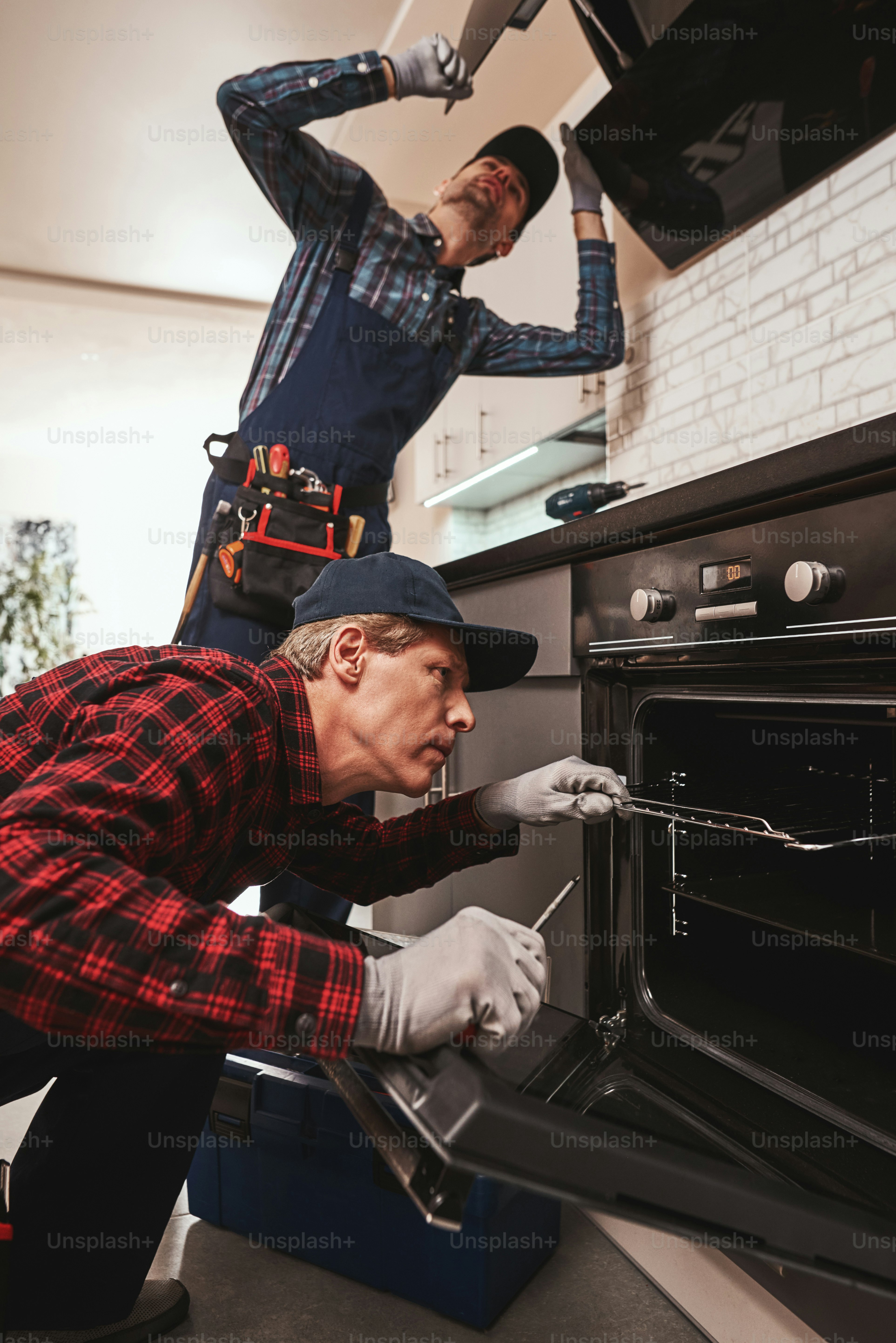 Productive together. Photo of two mechanics working at the kitchen ...