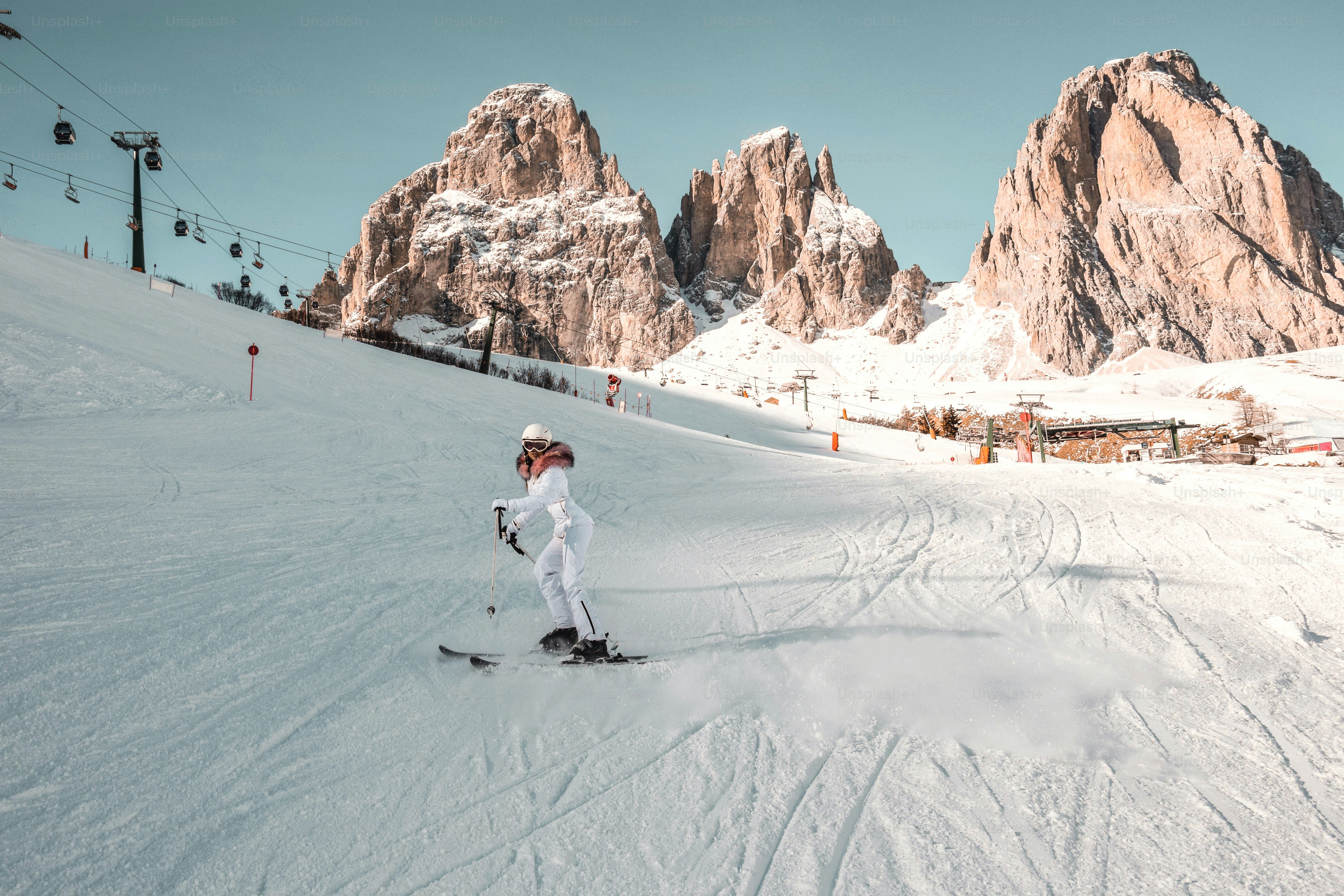Snowy white winter day in high mountains. Woman in fashionable jacket ...