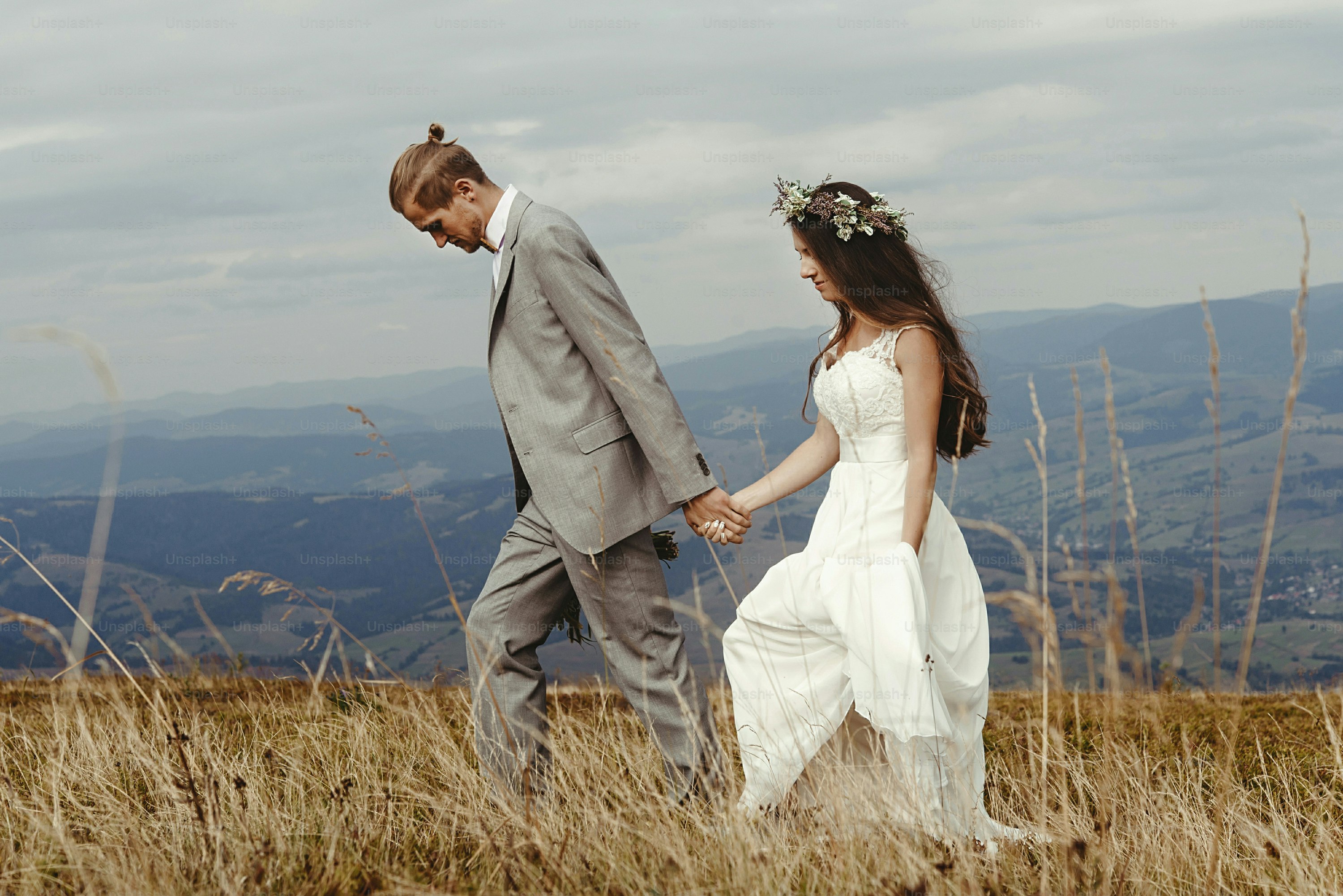 Heureux magnifique mariée et le marié marchant dans la lumière du ...