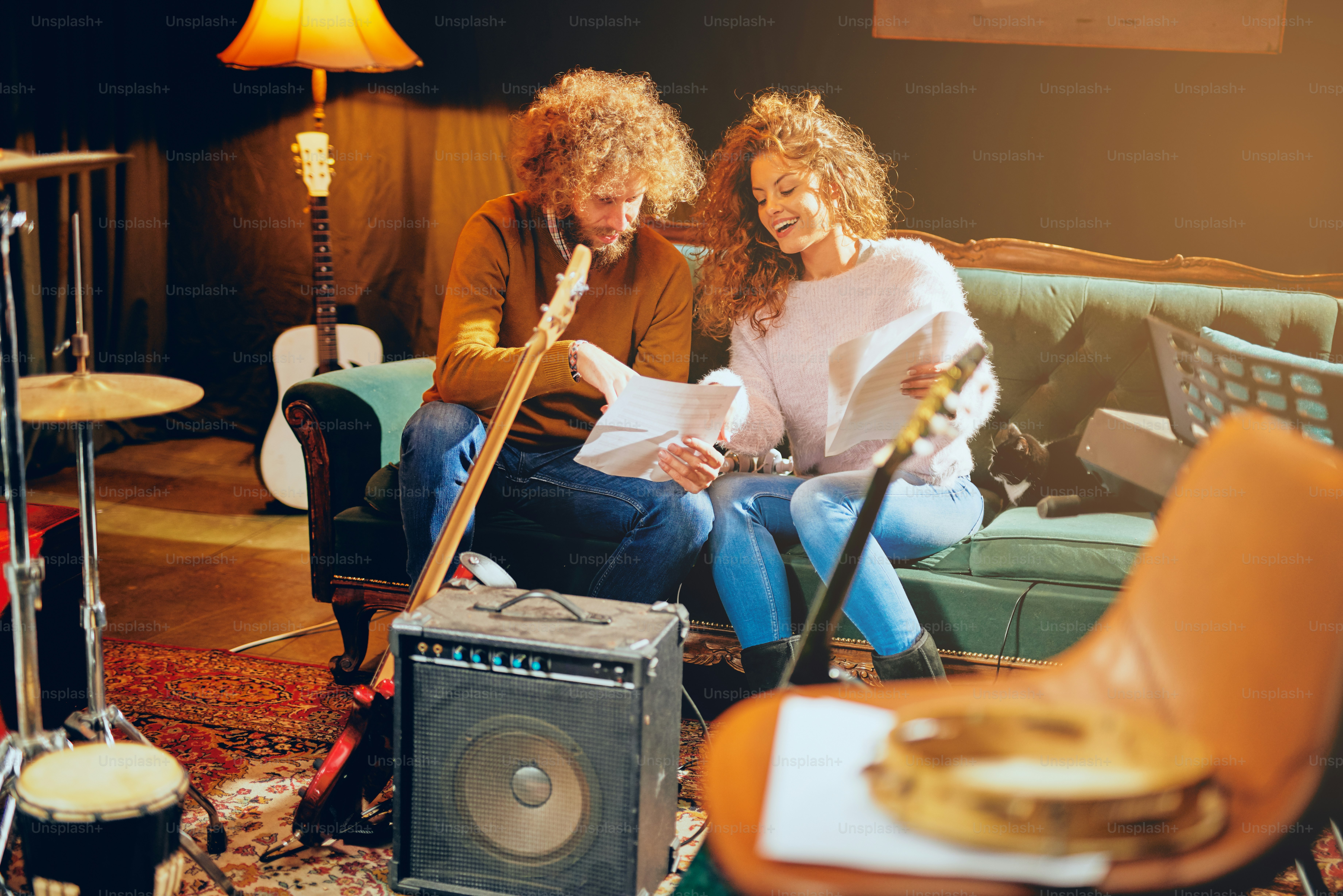 Woman and man with curly hair looking at notes and preparing for the ...