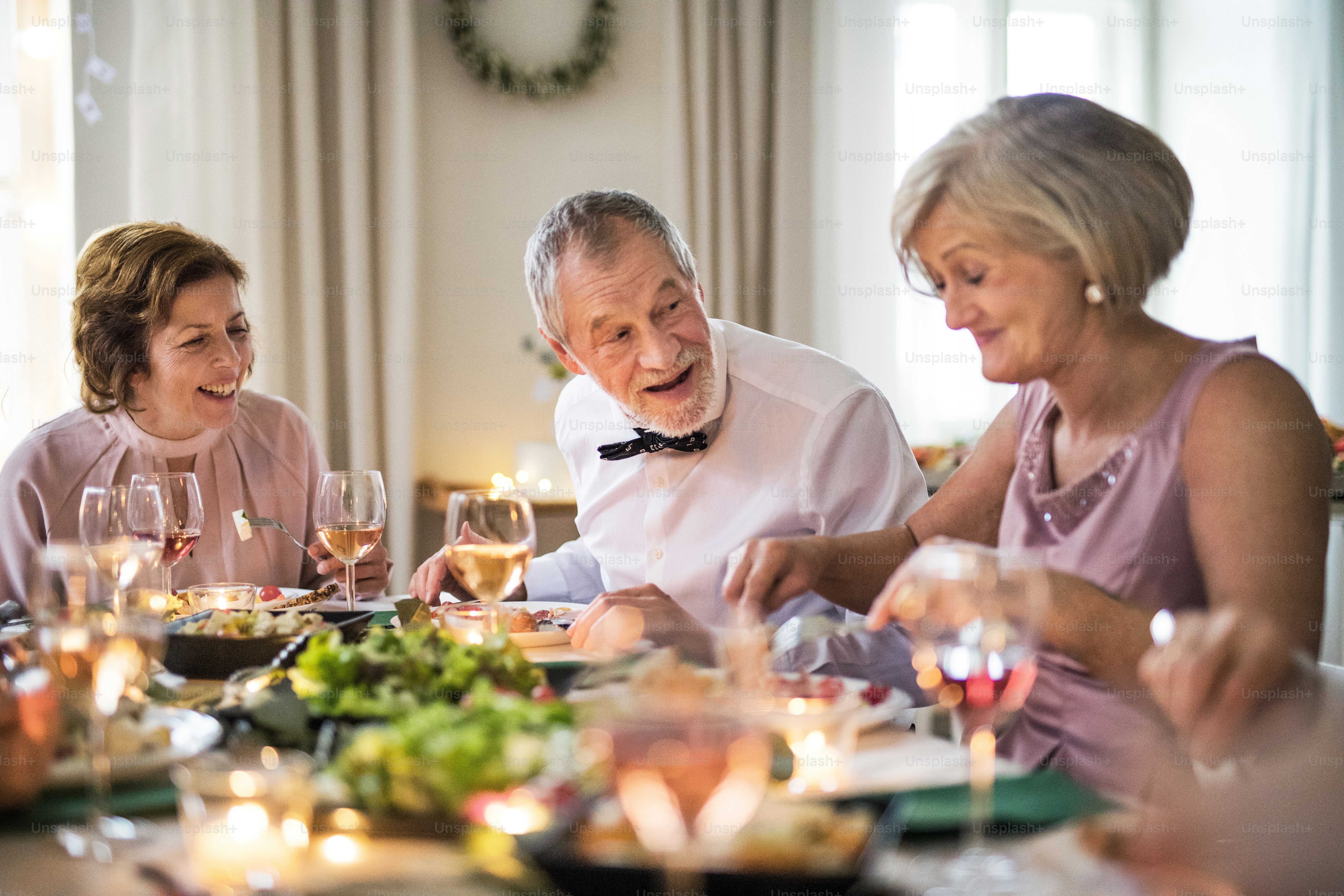 Des personnes âgées joyeuses assises à la table d’une fête d ...