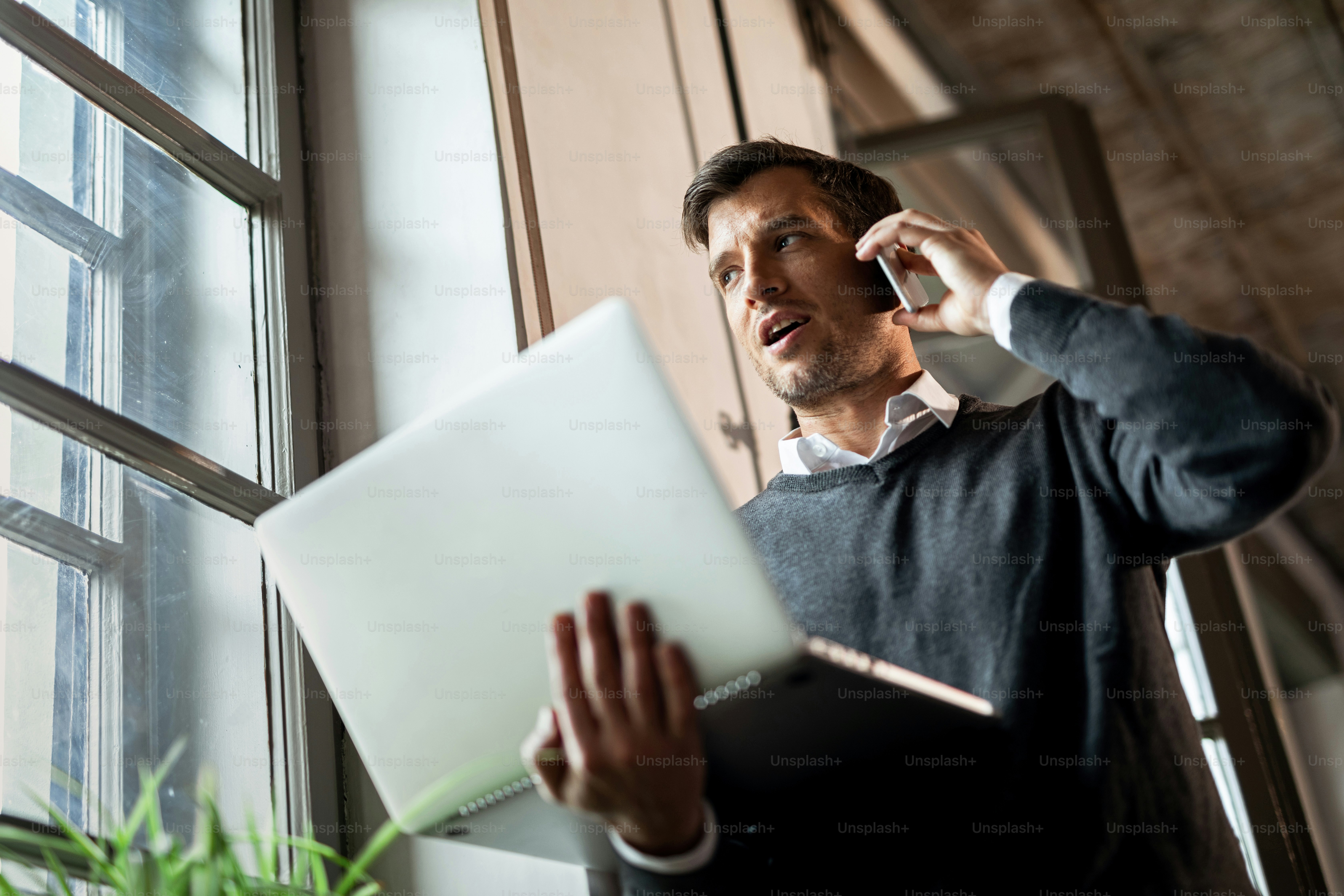 Low angle view of businessman looking though the window while ...