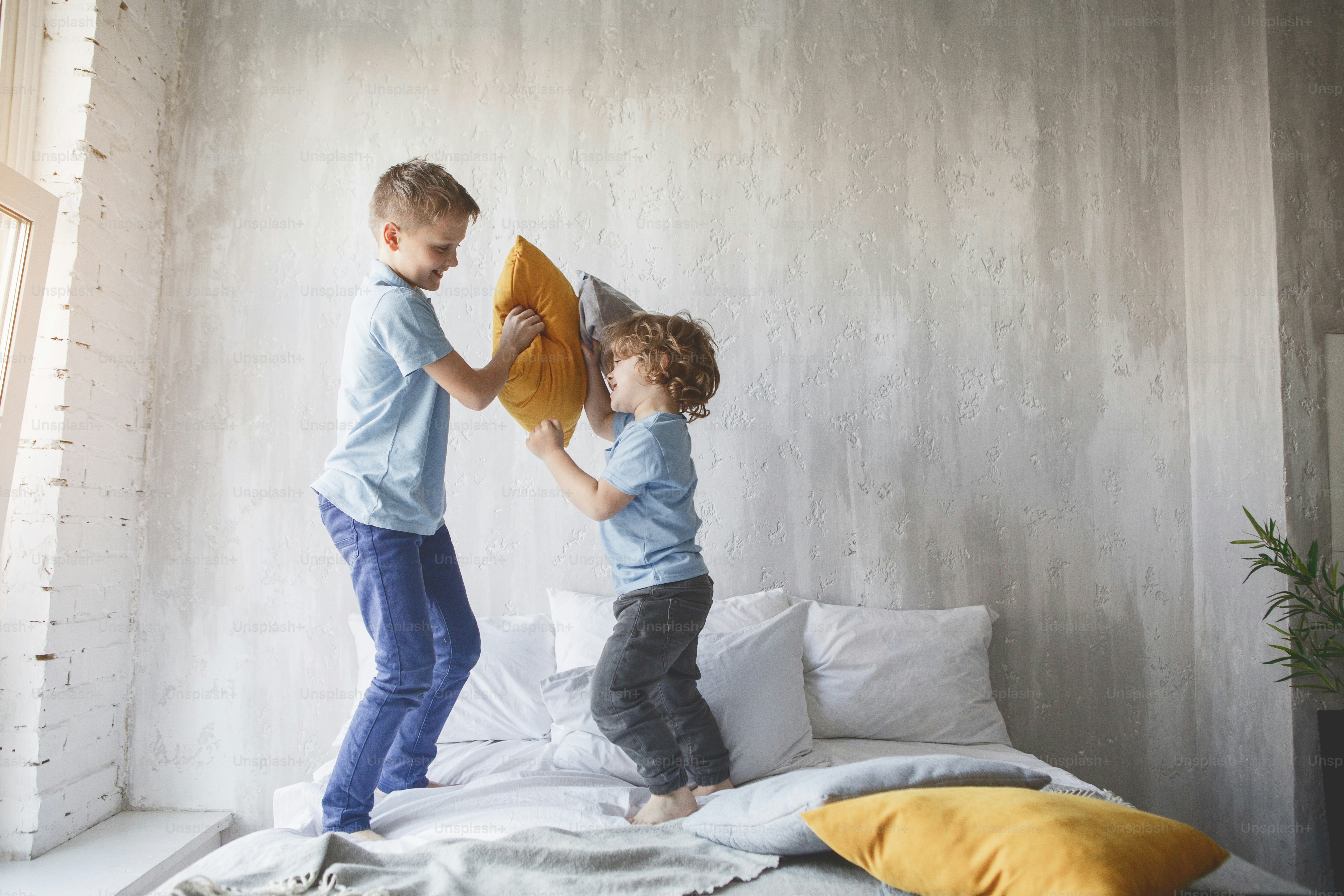 Full length side view outgoing boy playing with cheerful little brother ...