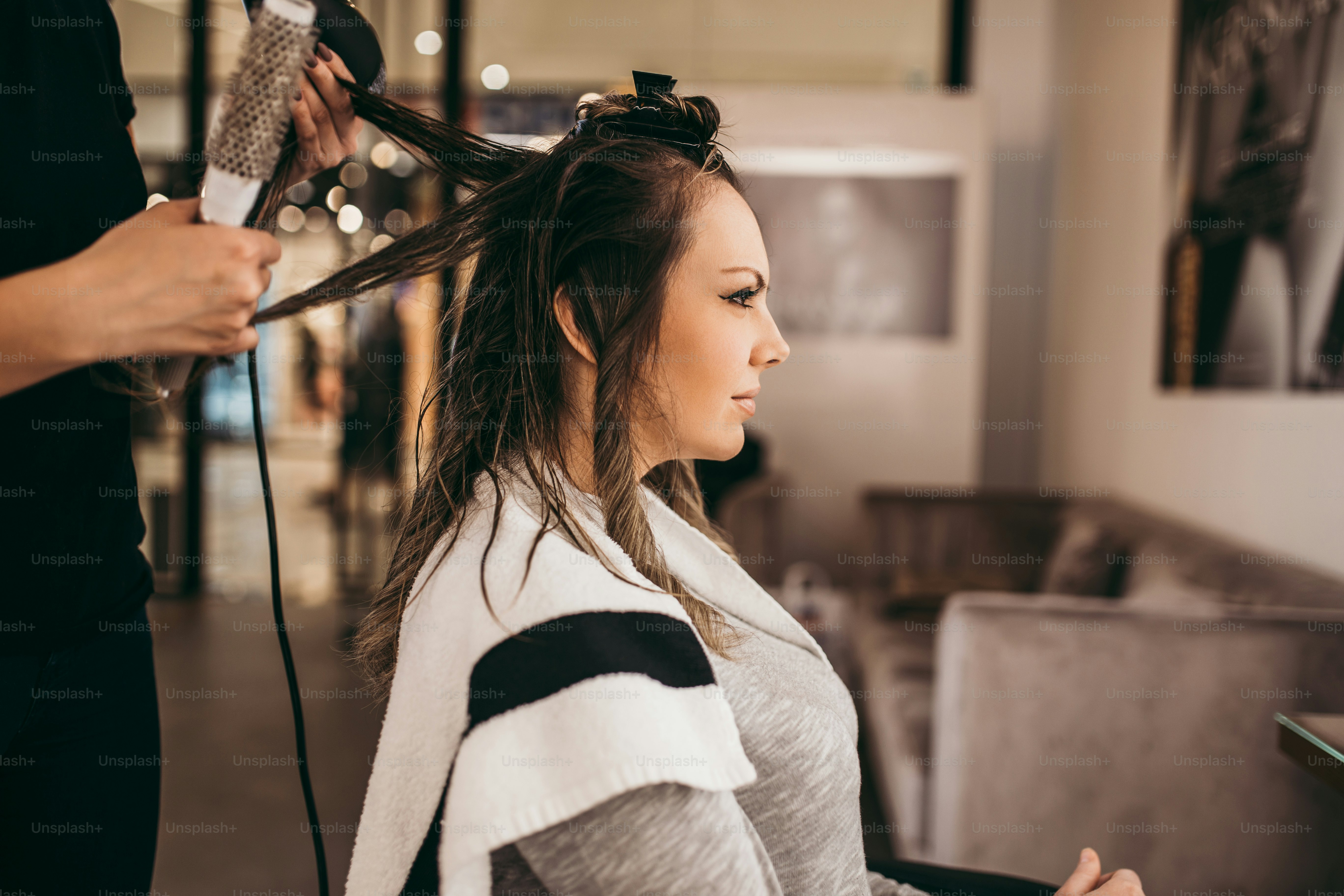 Beautiful brunette woman with long hair at the beauty salon getting a ...