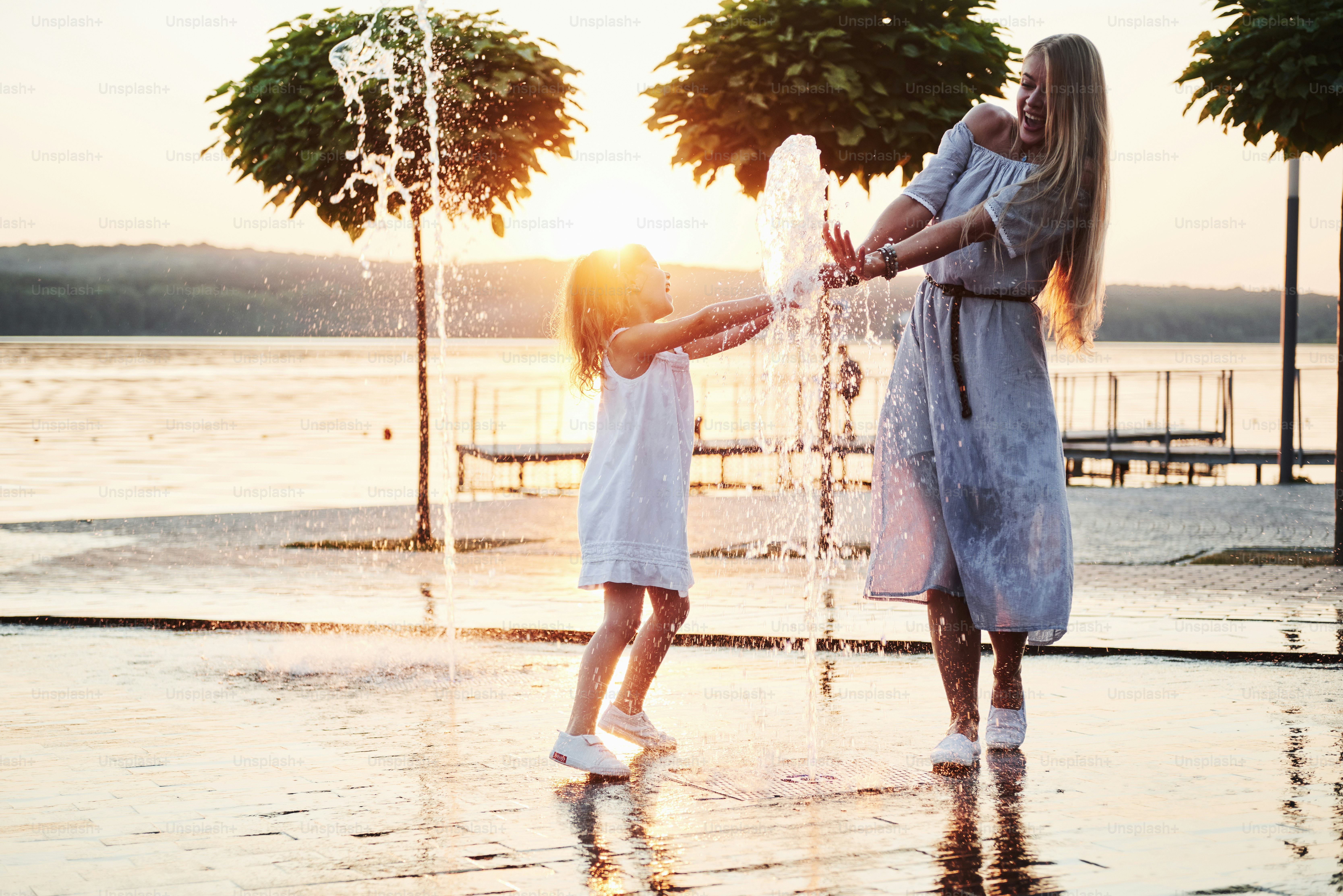 Mother with baby near the fountain at sunset. photo – Pregnant Image on ...