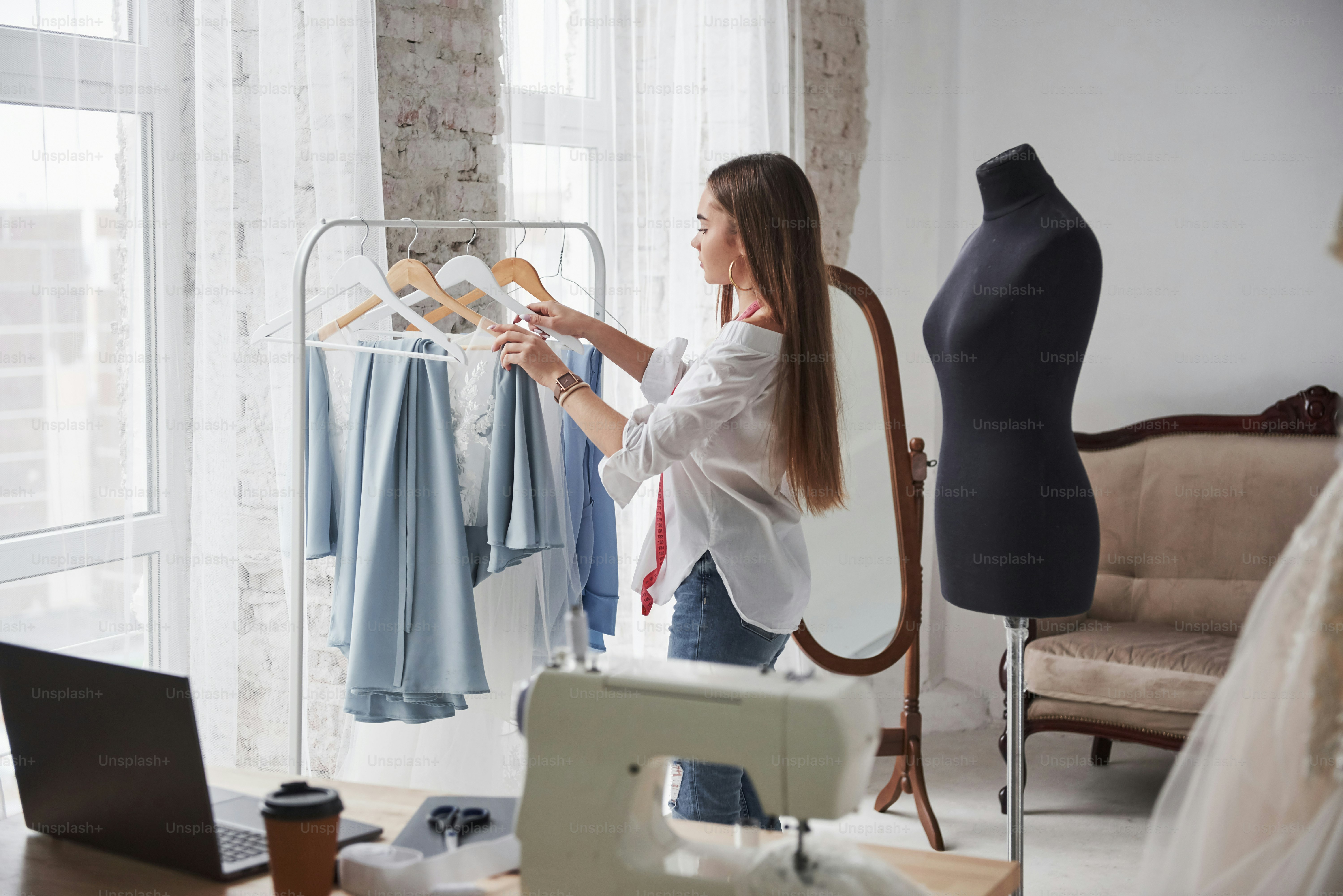 Choosing material. Female fashion designer works on the new clothes in ...
