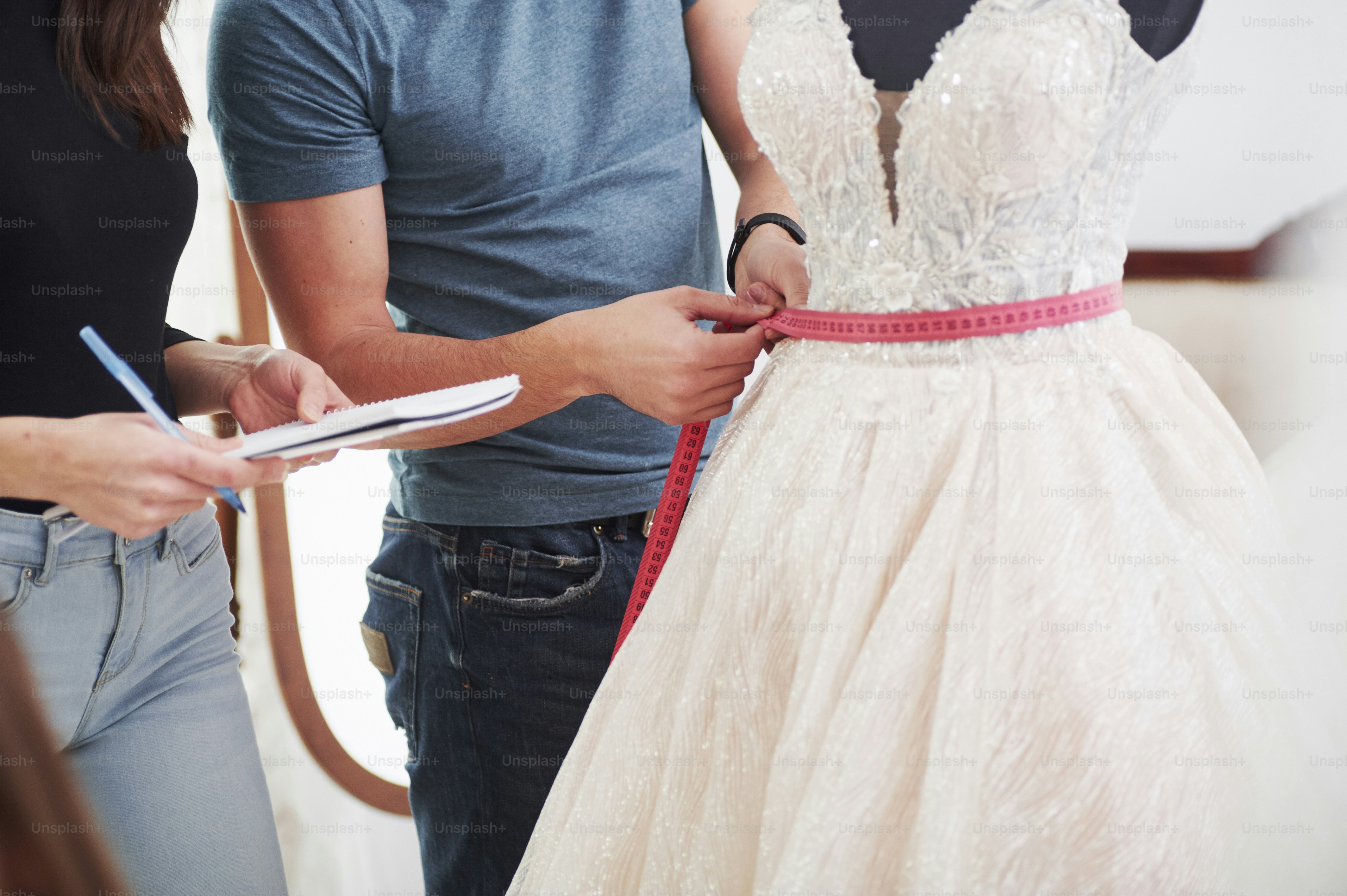 Man measure waist of mannequin. The process of fitting the dress in the ...