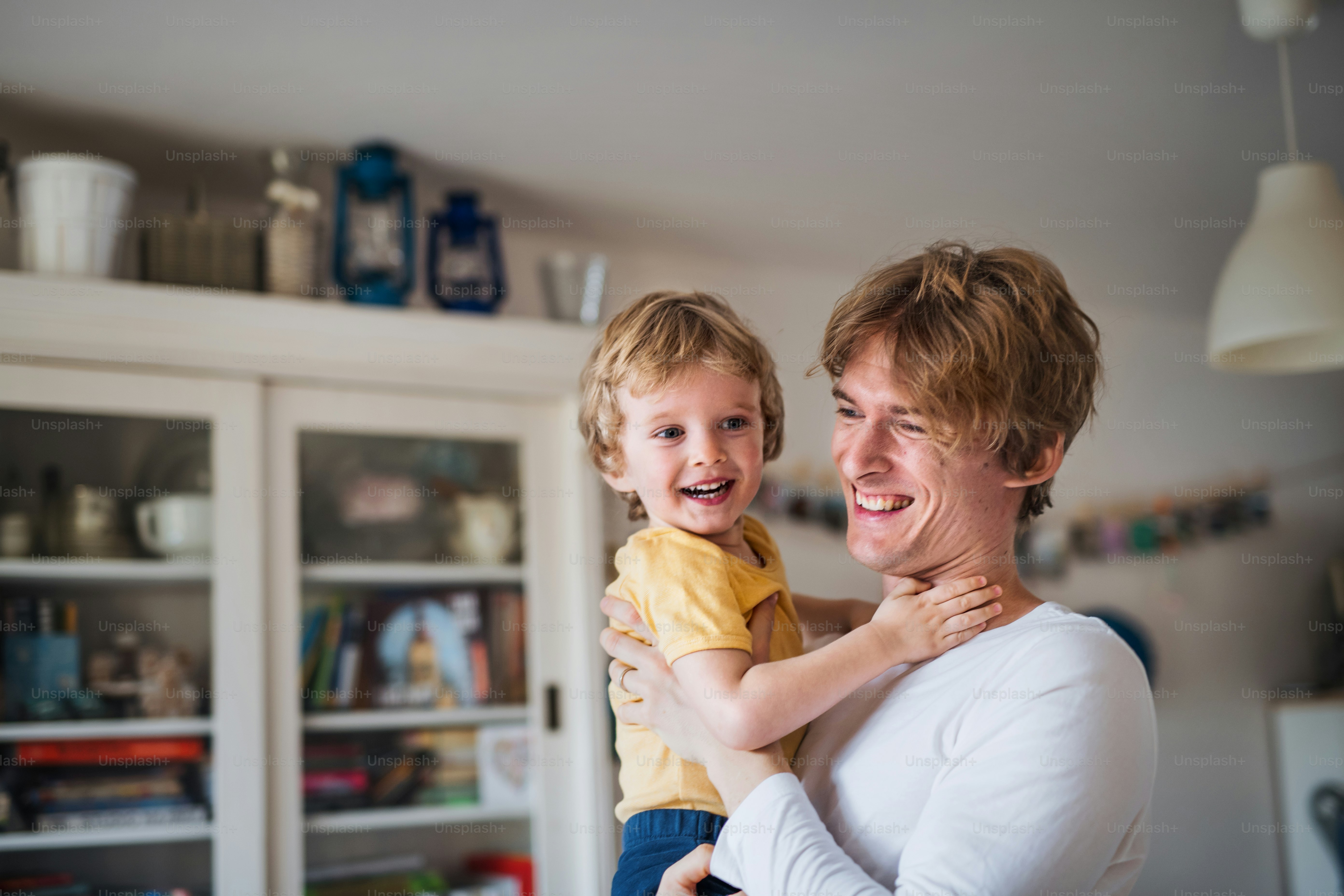 Un père heureux tenant un enfant en bas âge à la maison. photo ...