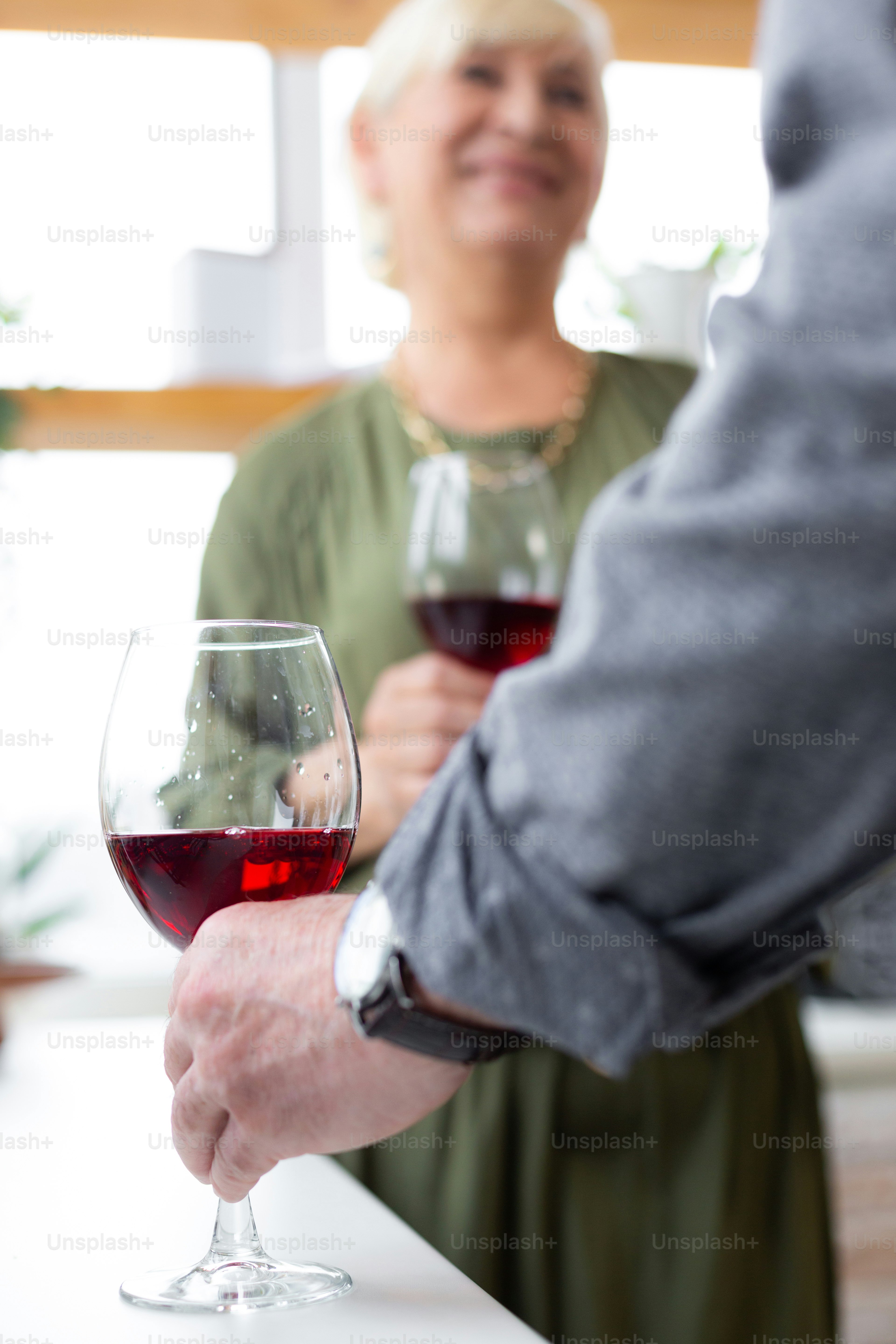 Raising a glass. Close-up picture of male hand with stylish watch on a ...