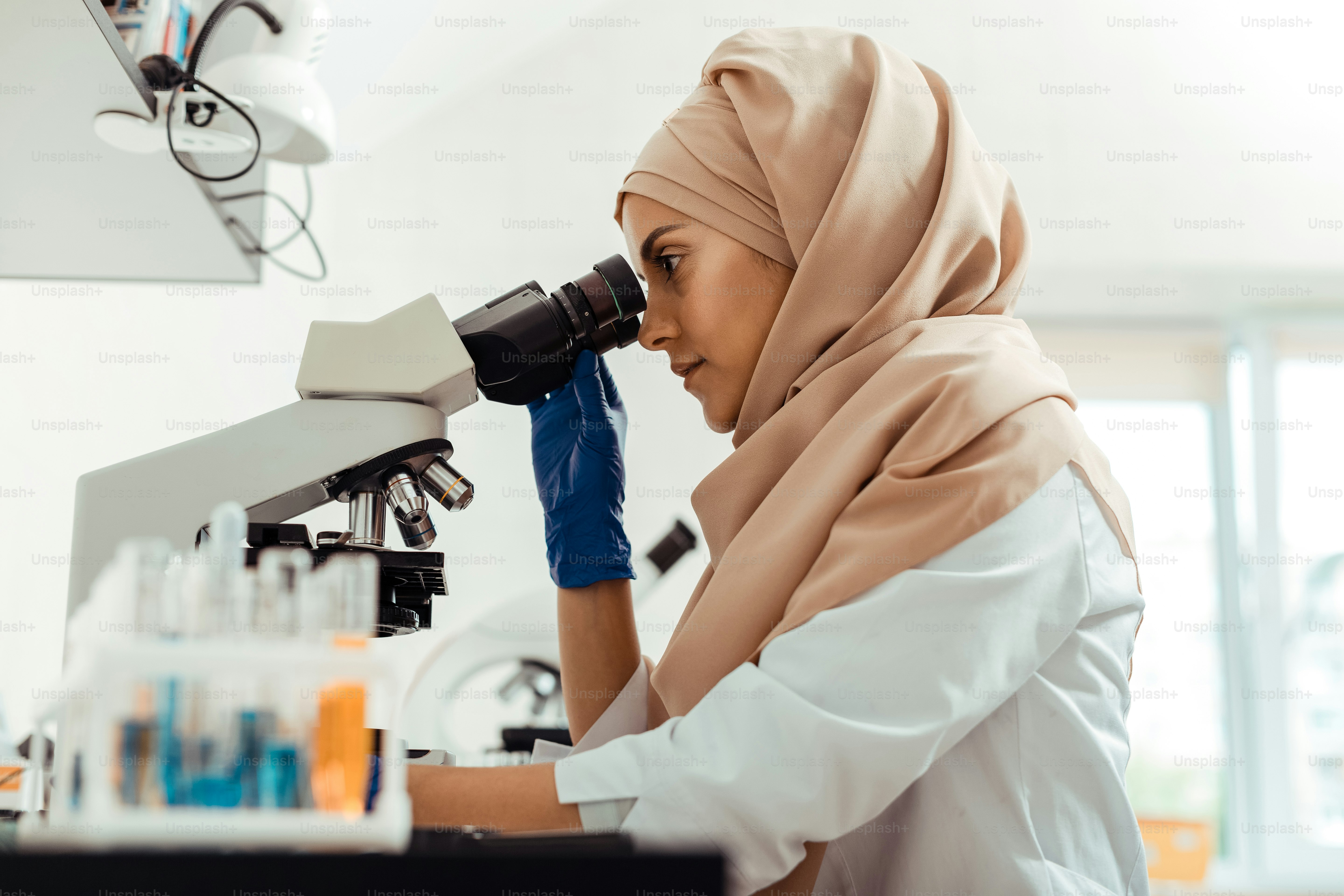 Devoted scientist. Intelligent young woman sitting in front of the ...