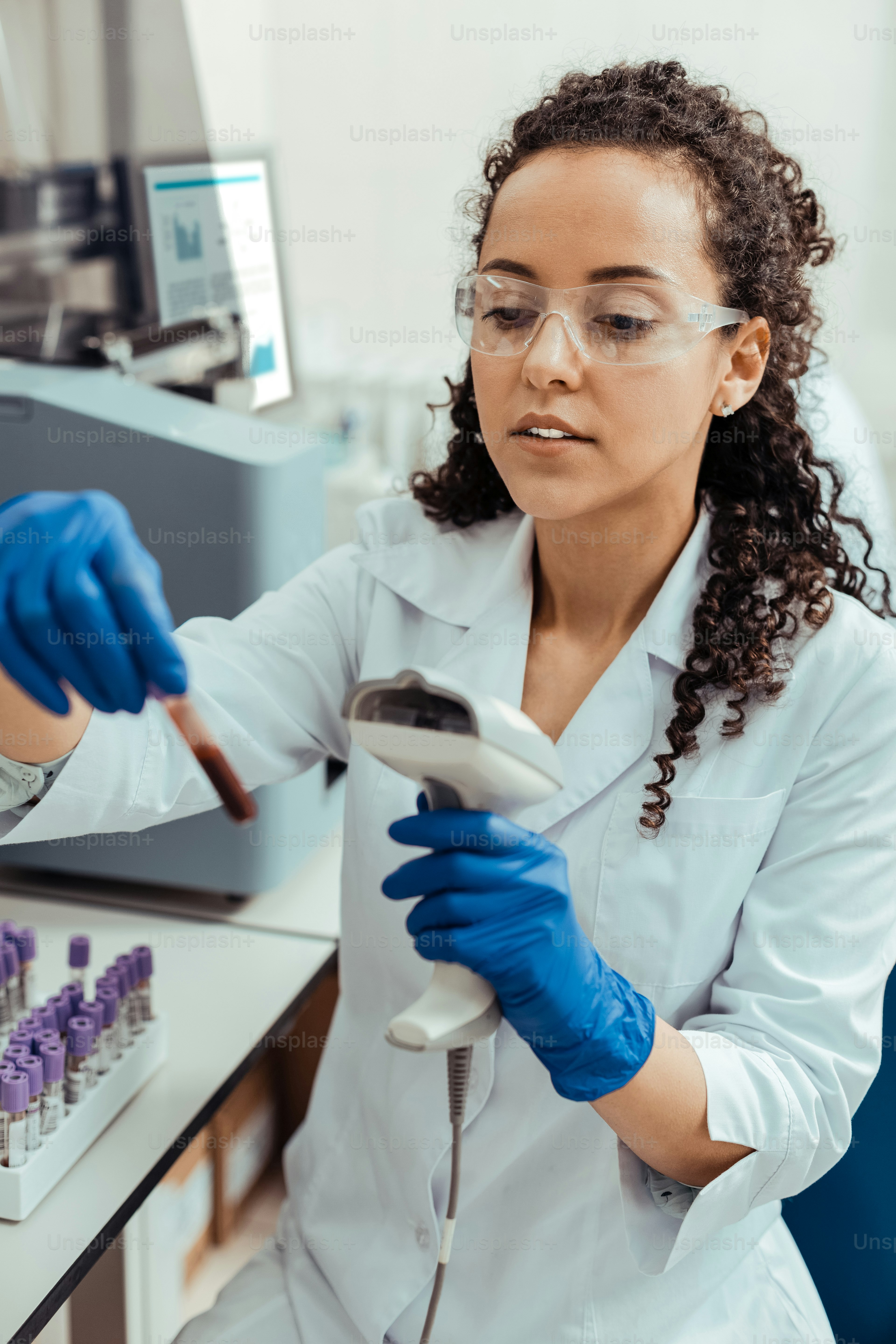 Blood analysis. Beautiful serious woman holding a scanner while doing ...