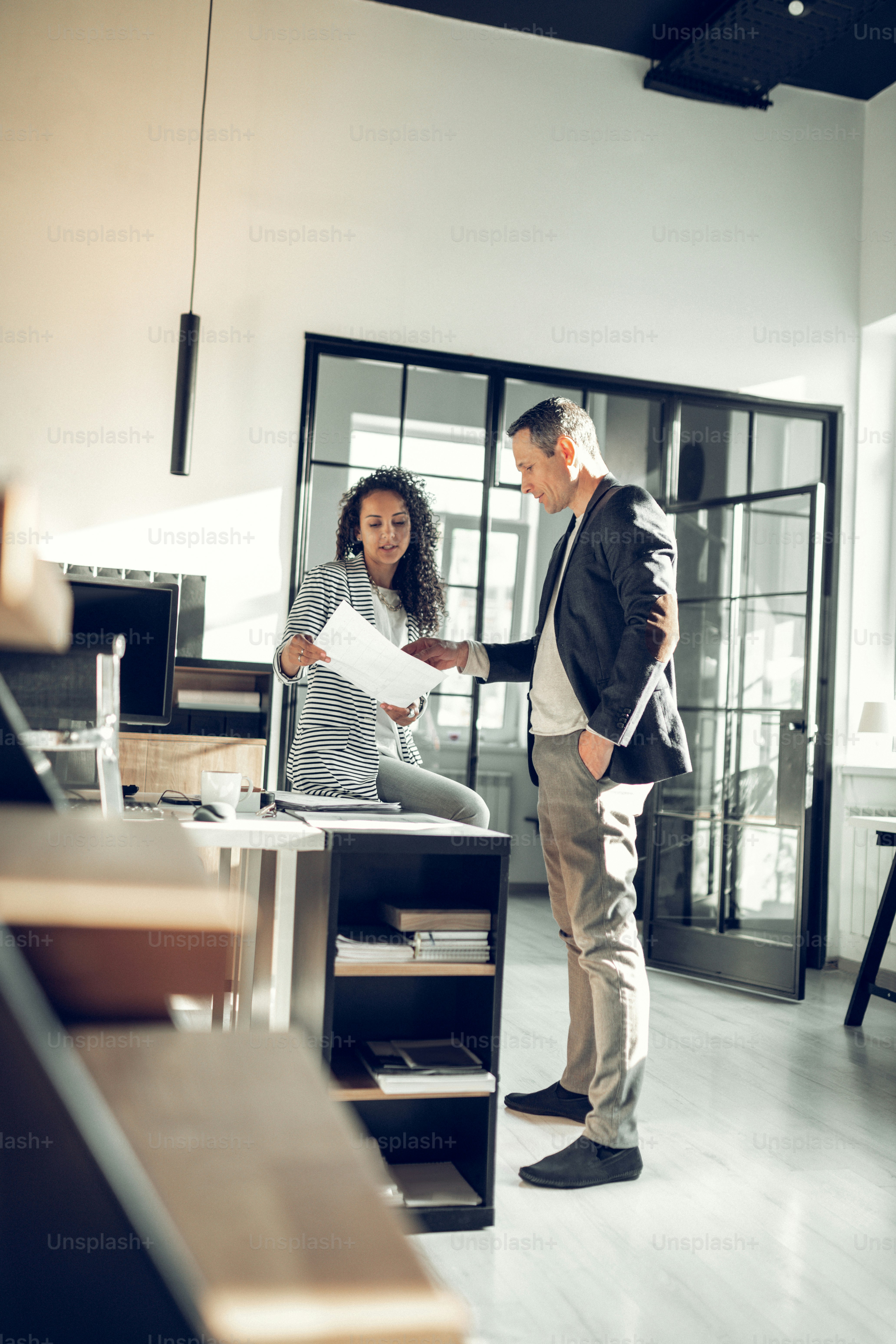 Talking to CEO. Curly dark-haired trainee of international company ...