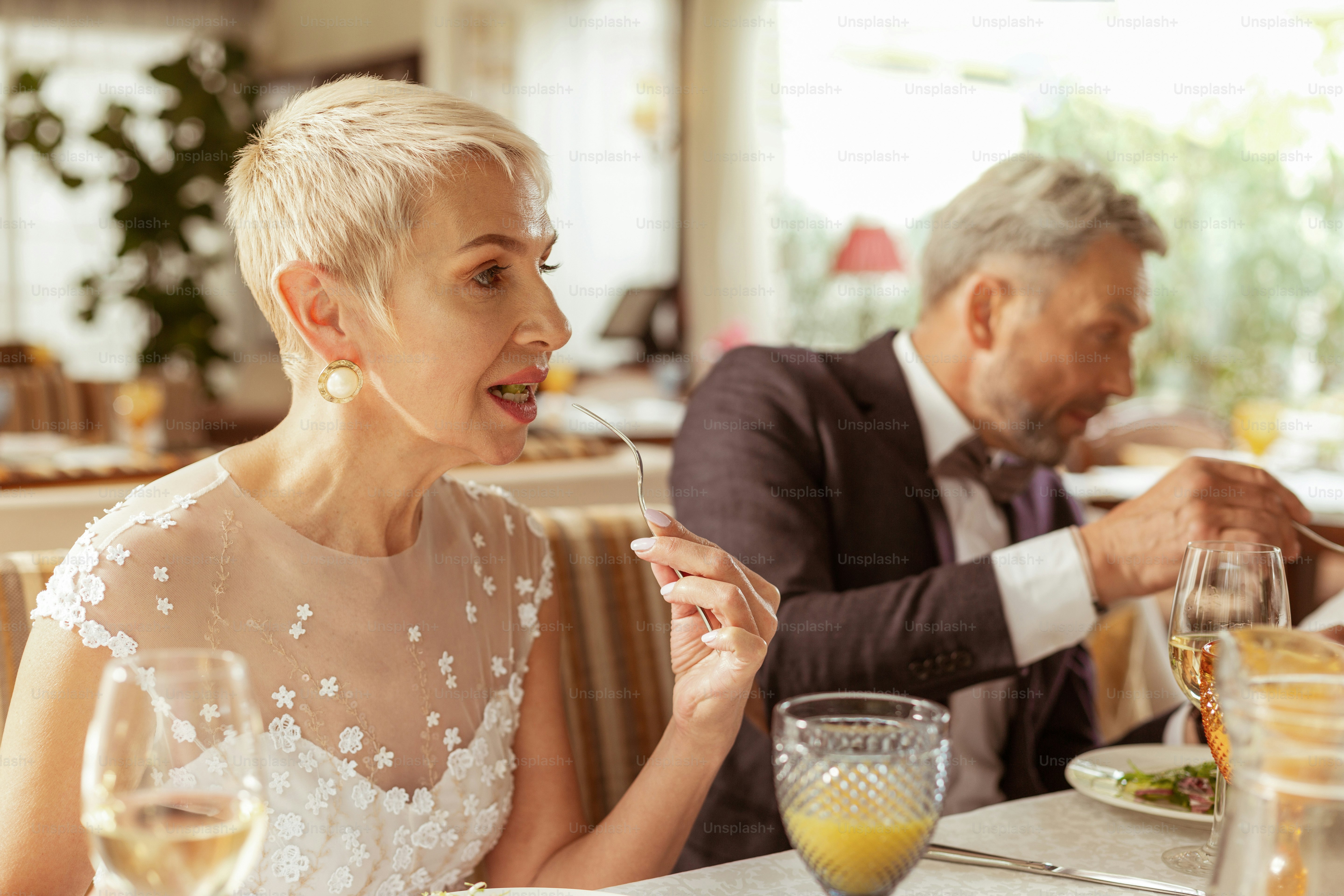 Bride eating salad. Beautiful aged bride eating salad while celebrating ...