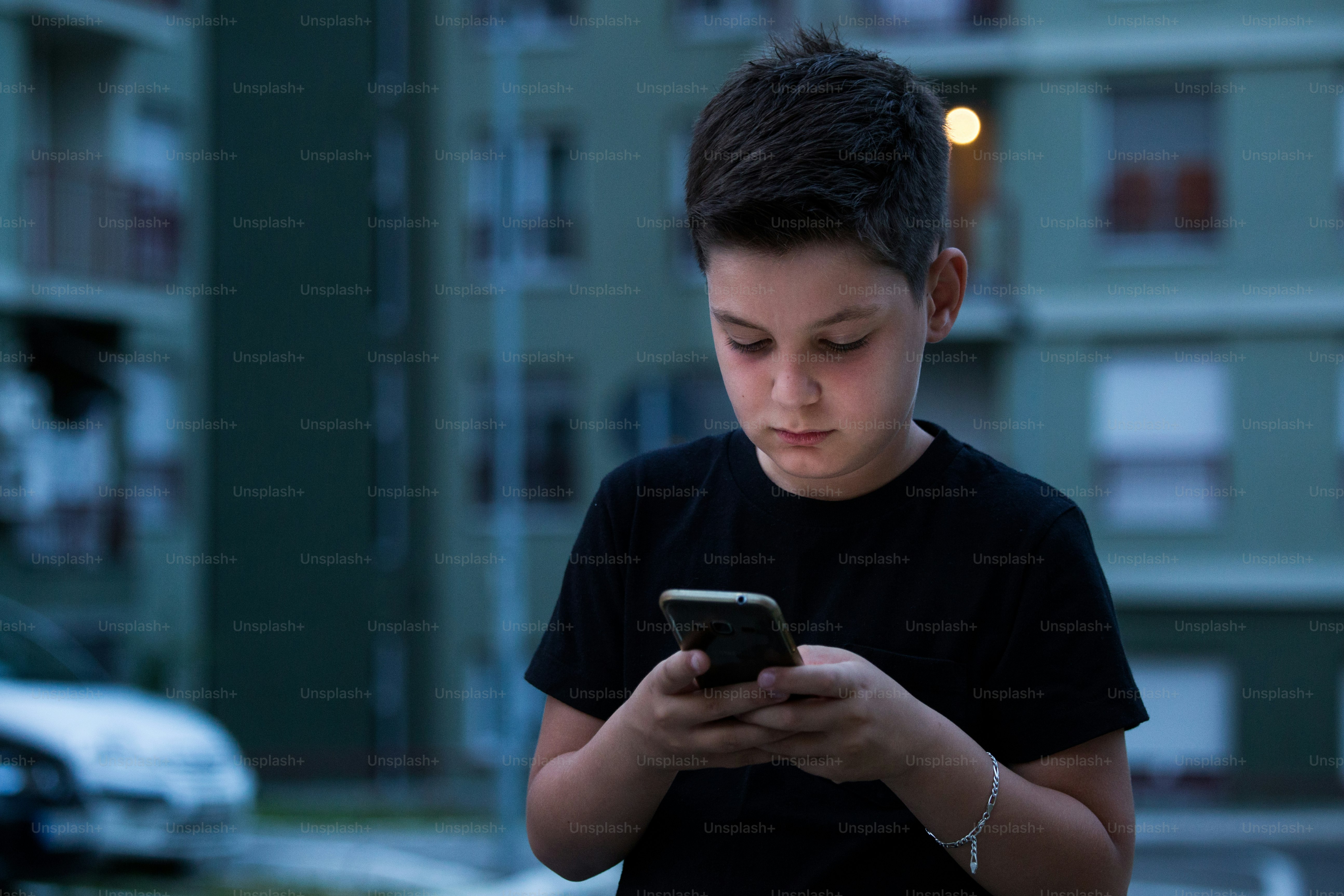Portrait of a sad teenage boy on the phone looking thoughtful about ...