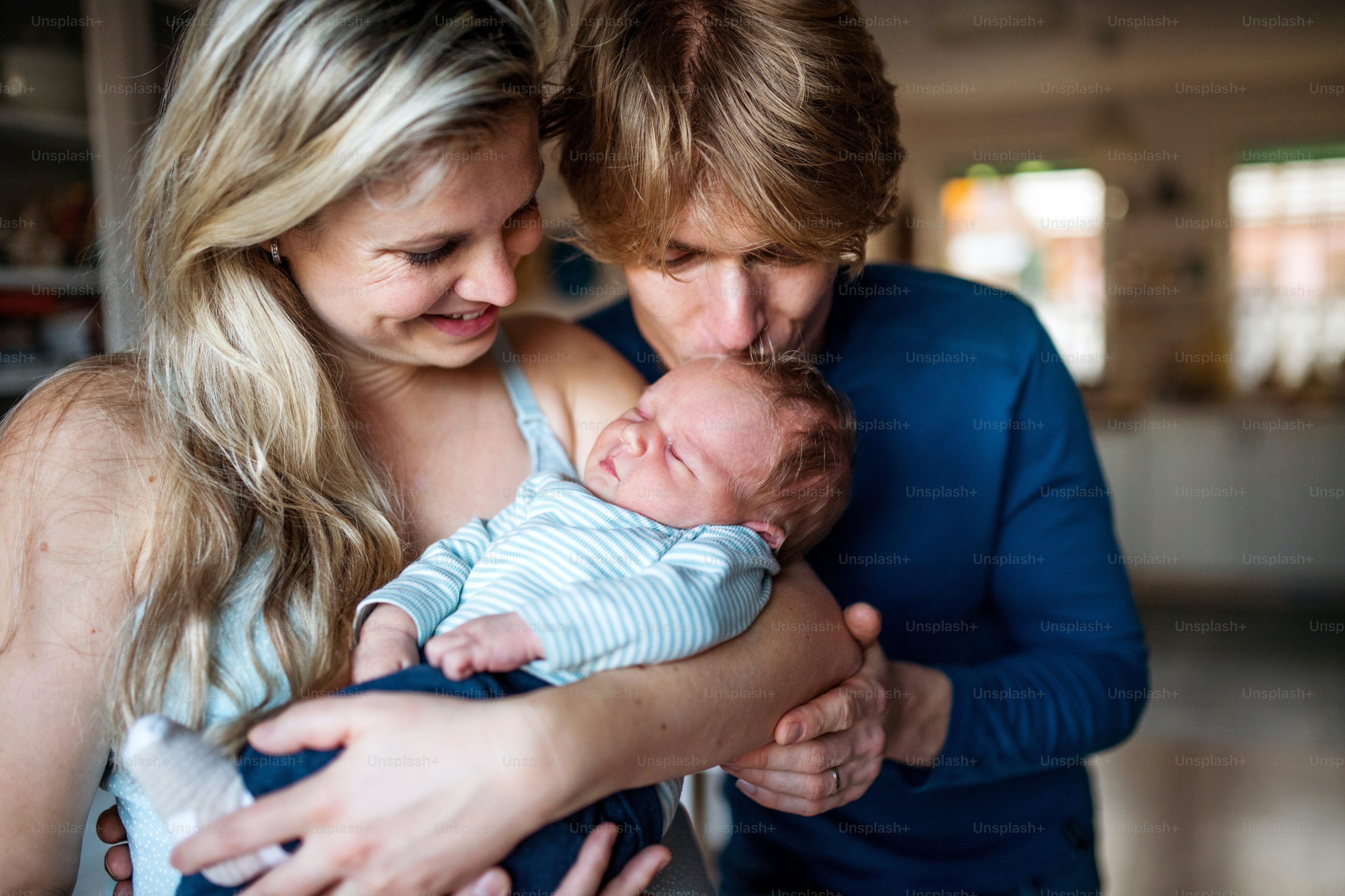 Beautiful young parents holding a newborn baby at home. photo – Free ...