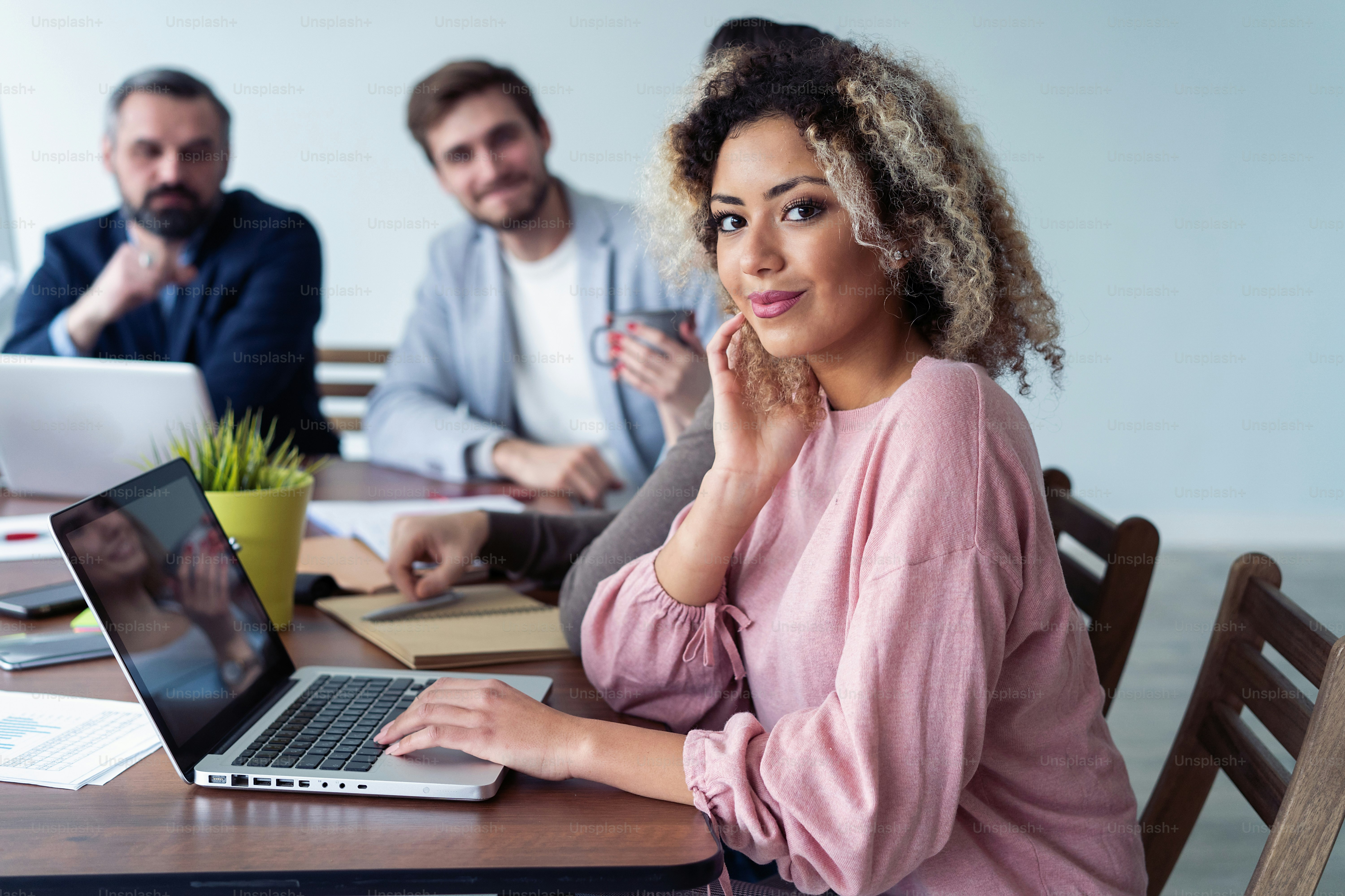 Beautiful business African lady is looking at camera and smiling while ...