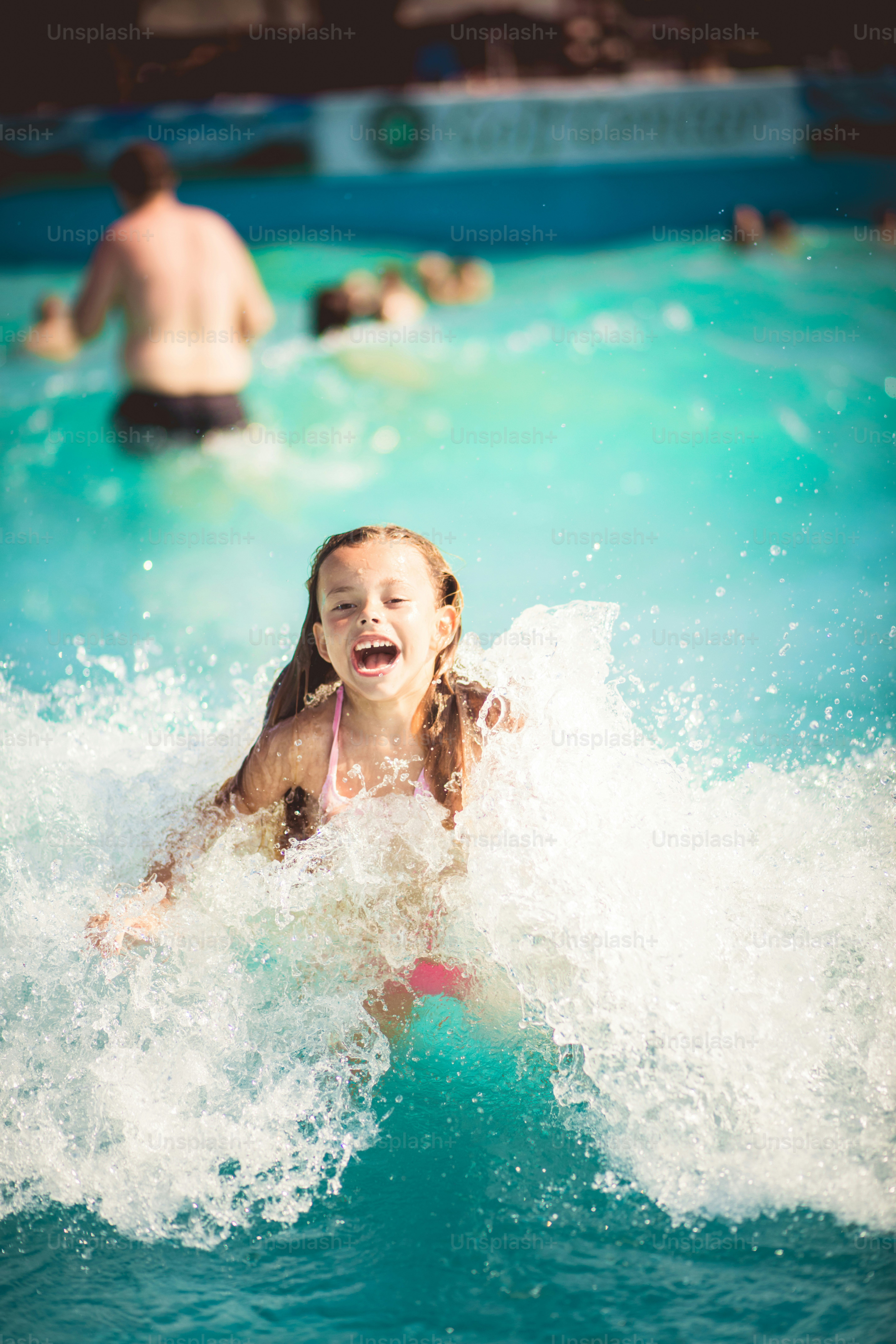 Foto zum Thema Sommerwellen voller Spaß. Kind schwimmt im Pool. – Bild ...