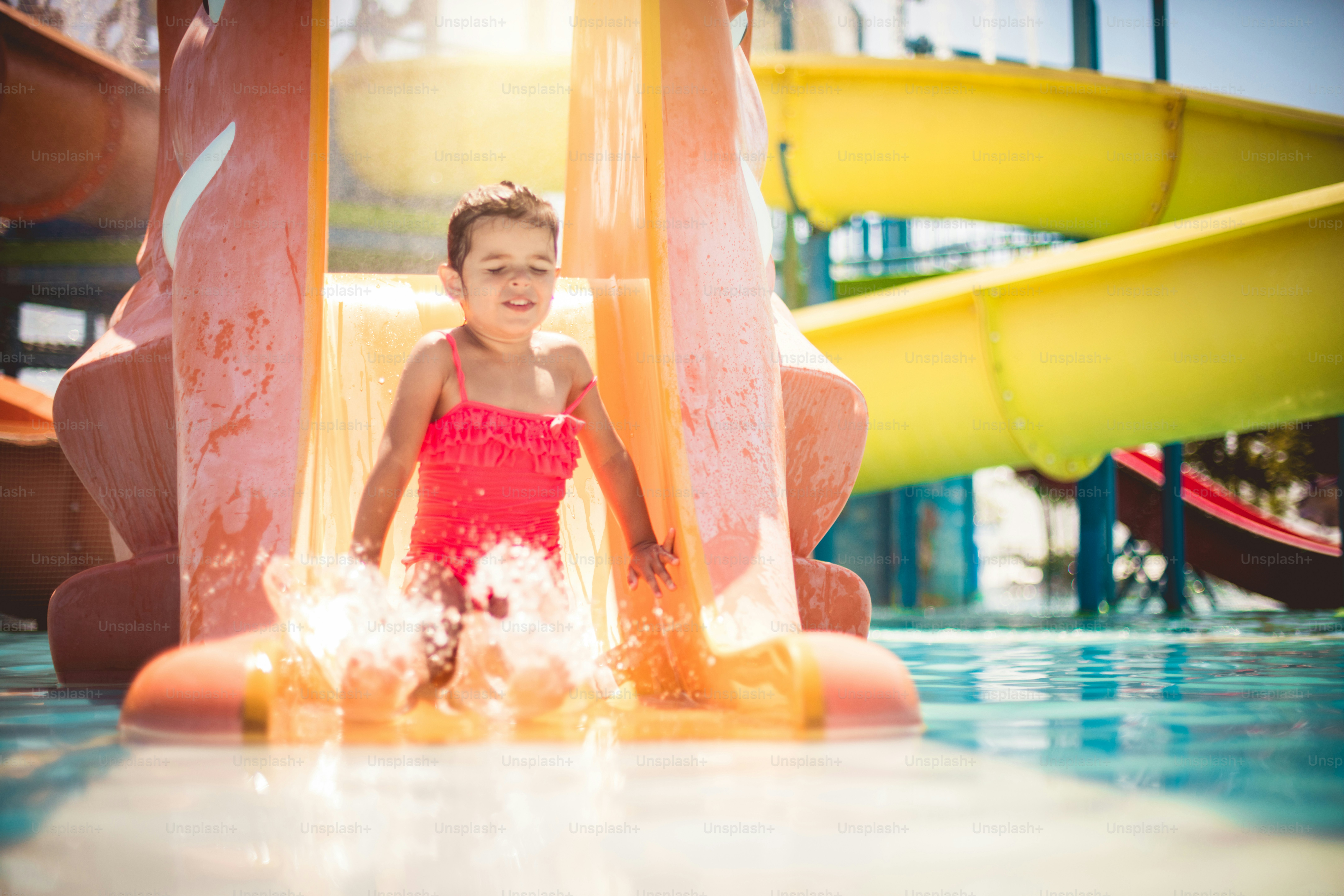 Summer is her favorite season. Little girl in pool. photo – Water slide ...