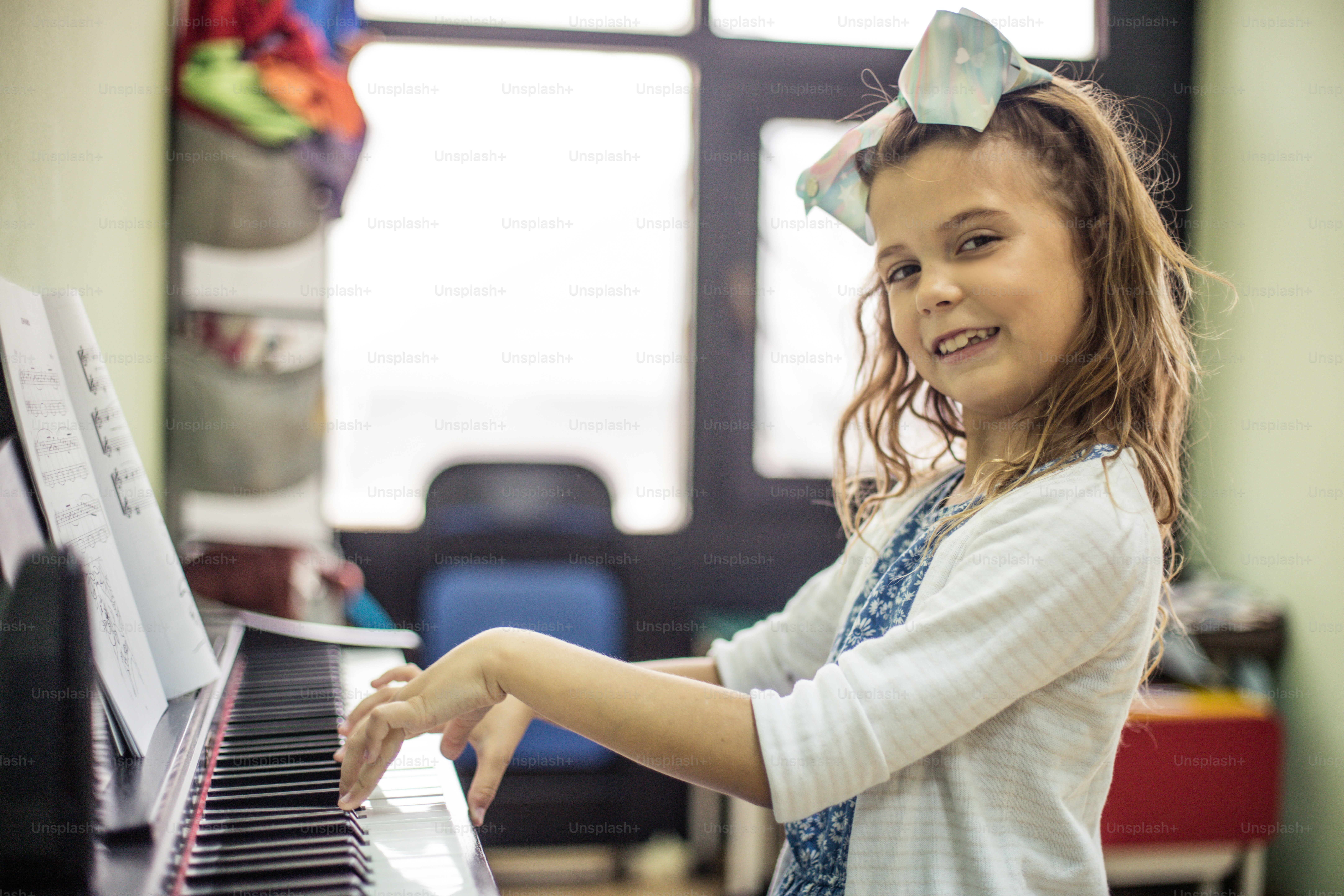 Foto Es una pianista en ciernes. Niña tocando el piano. – Instrumento ...
