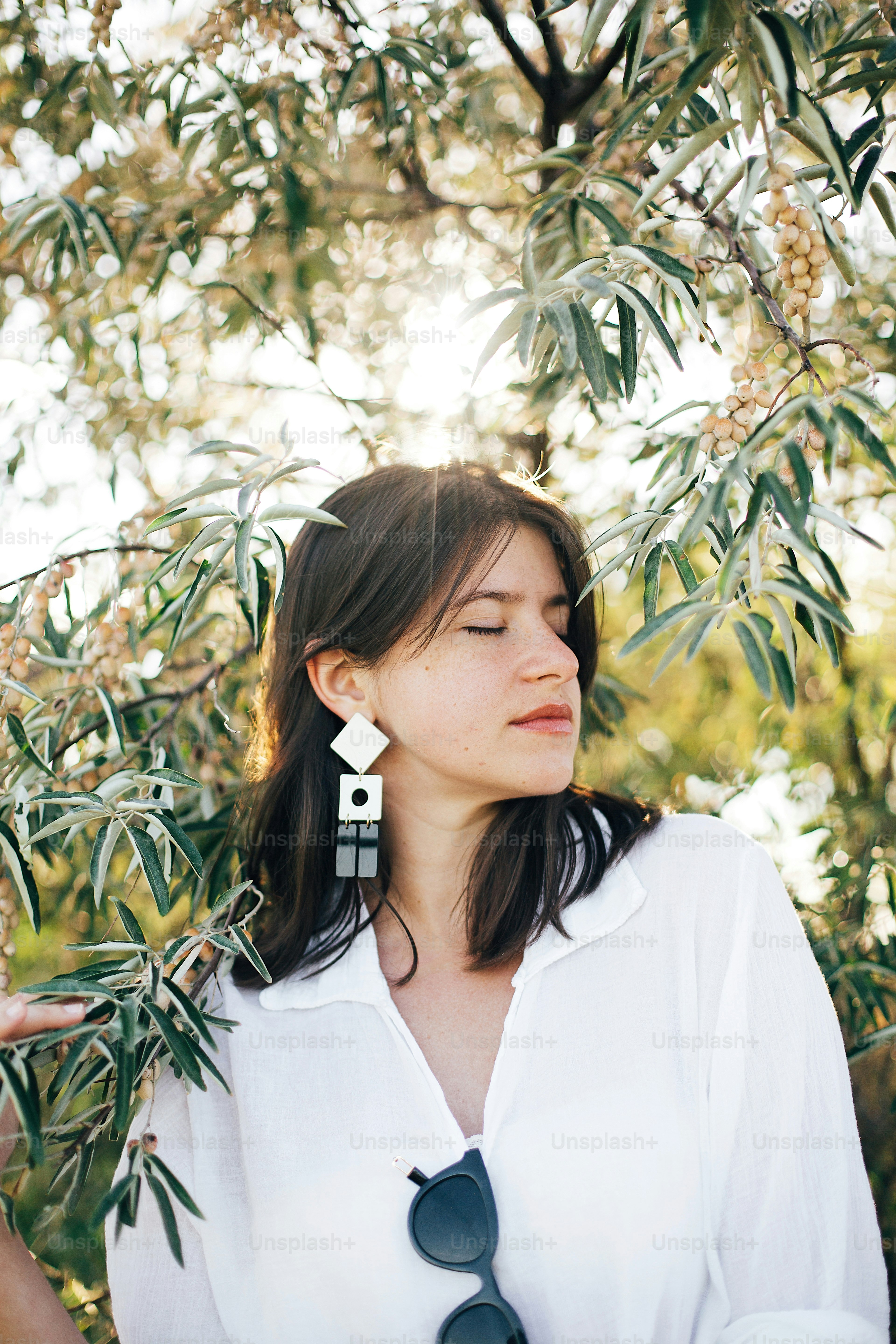 Portrait of young fashionable woman with modern earrings posing in ...