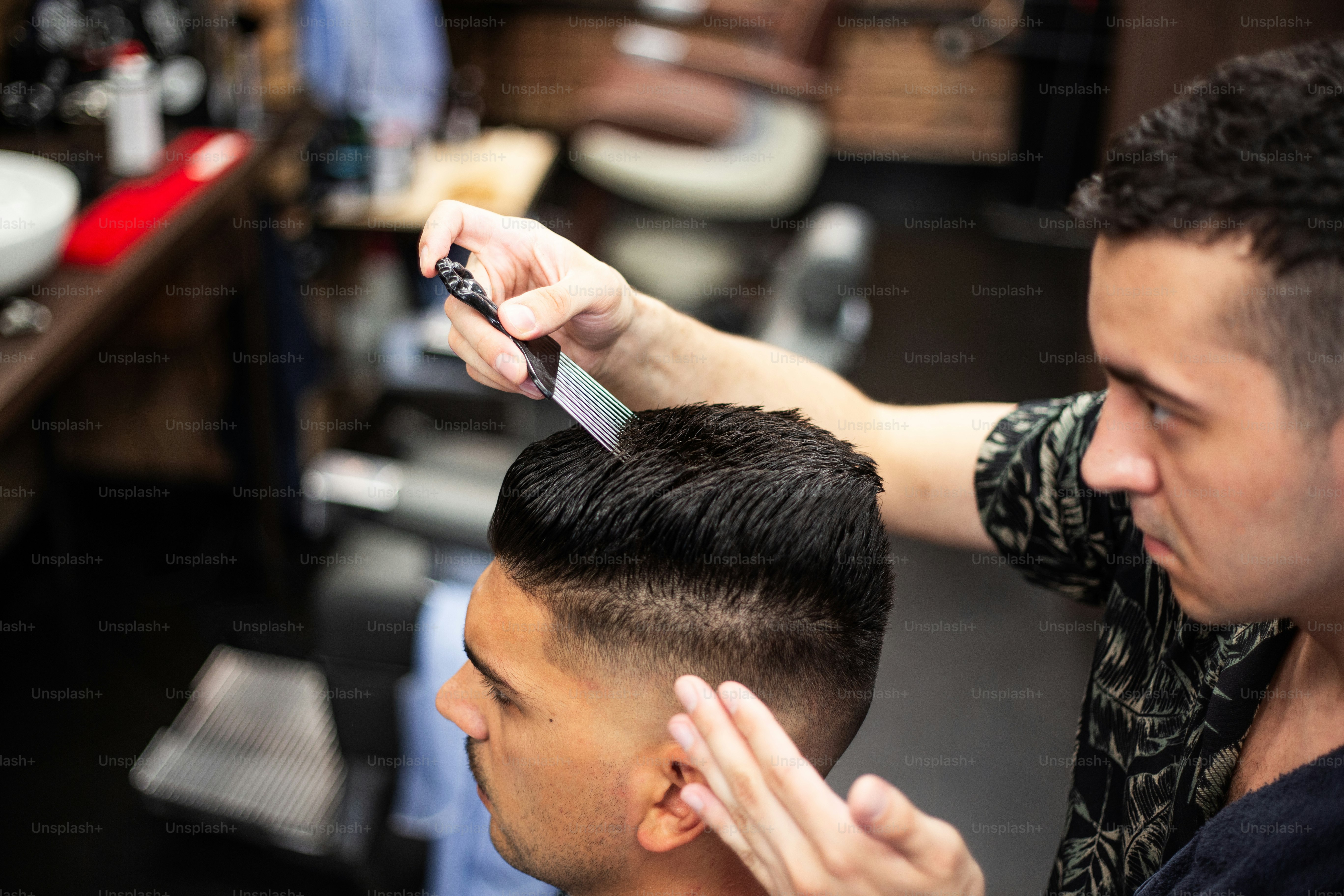 Barber shop. Man in barber's chair, hairdresser styling his hair photo ...