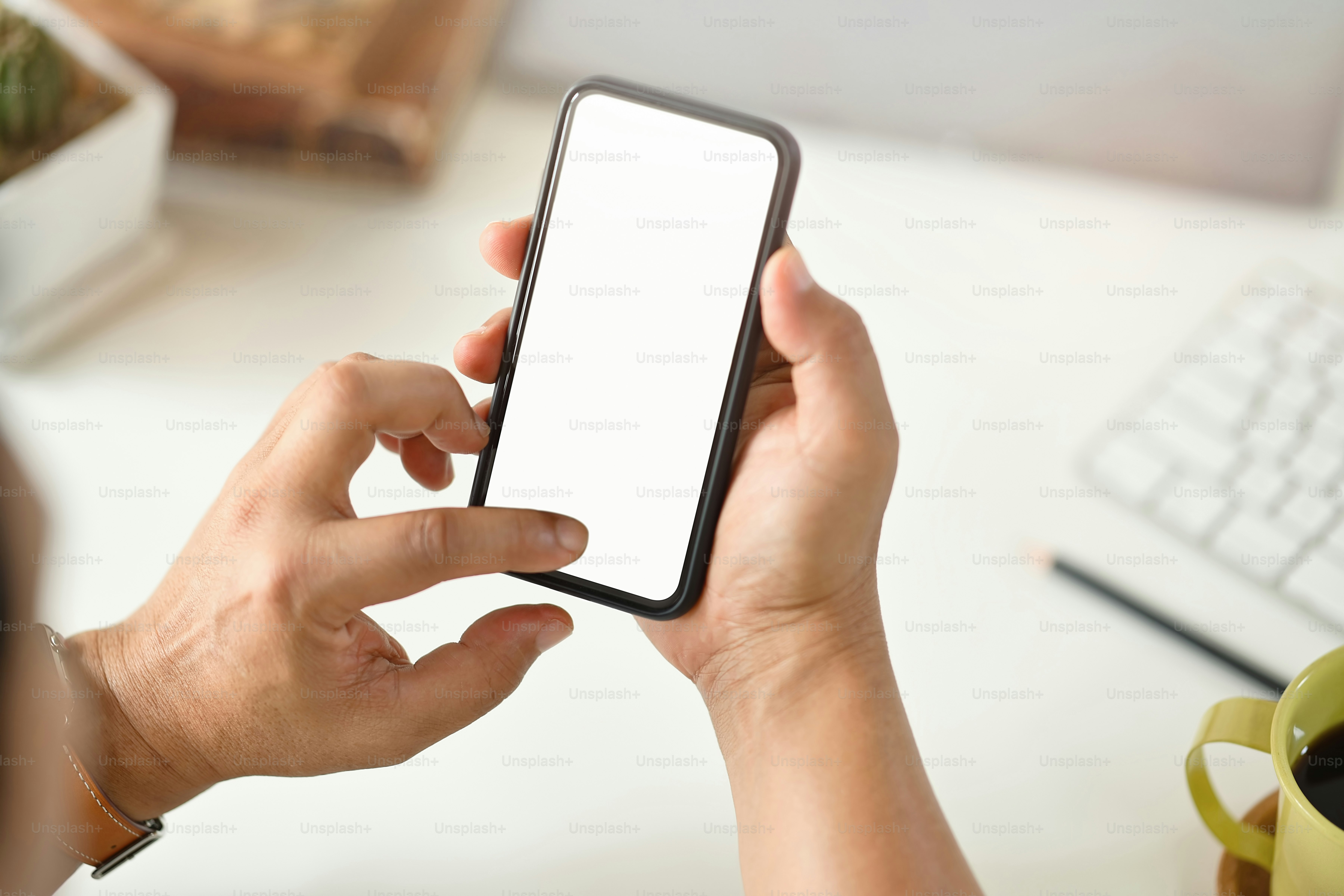 Cropped shot of businessman hand holding blank screen mobile phone at ...