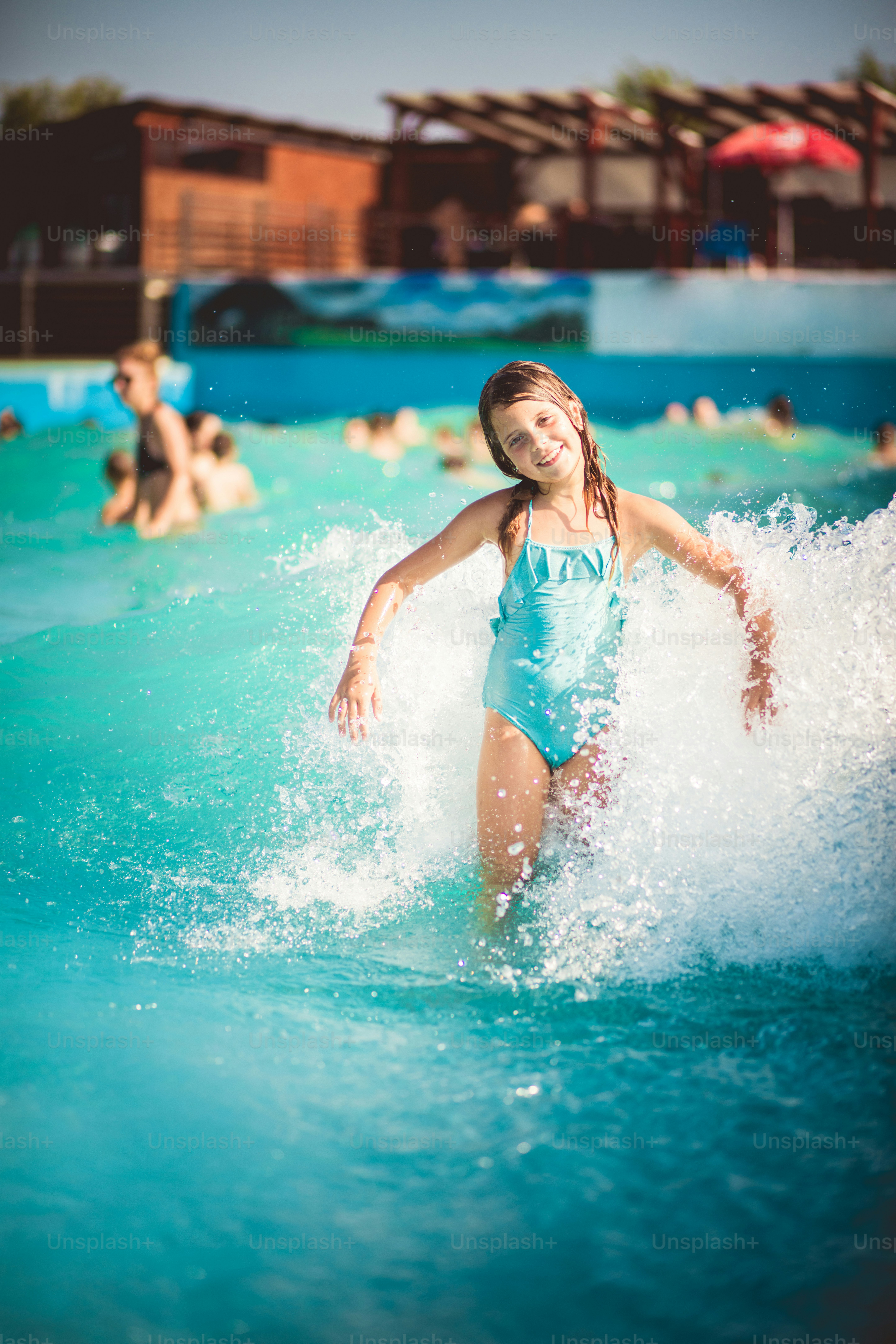 Foto zum Thema Wellen macht Spaß. Kleines Mädchen steht im Pool. – Bild ...