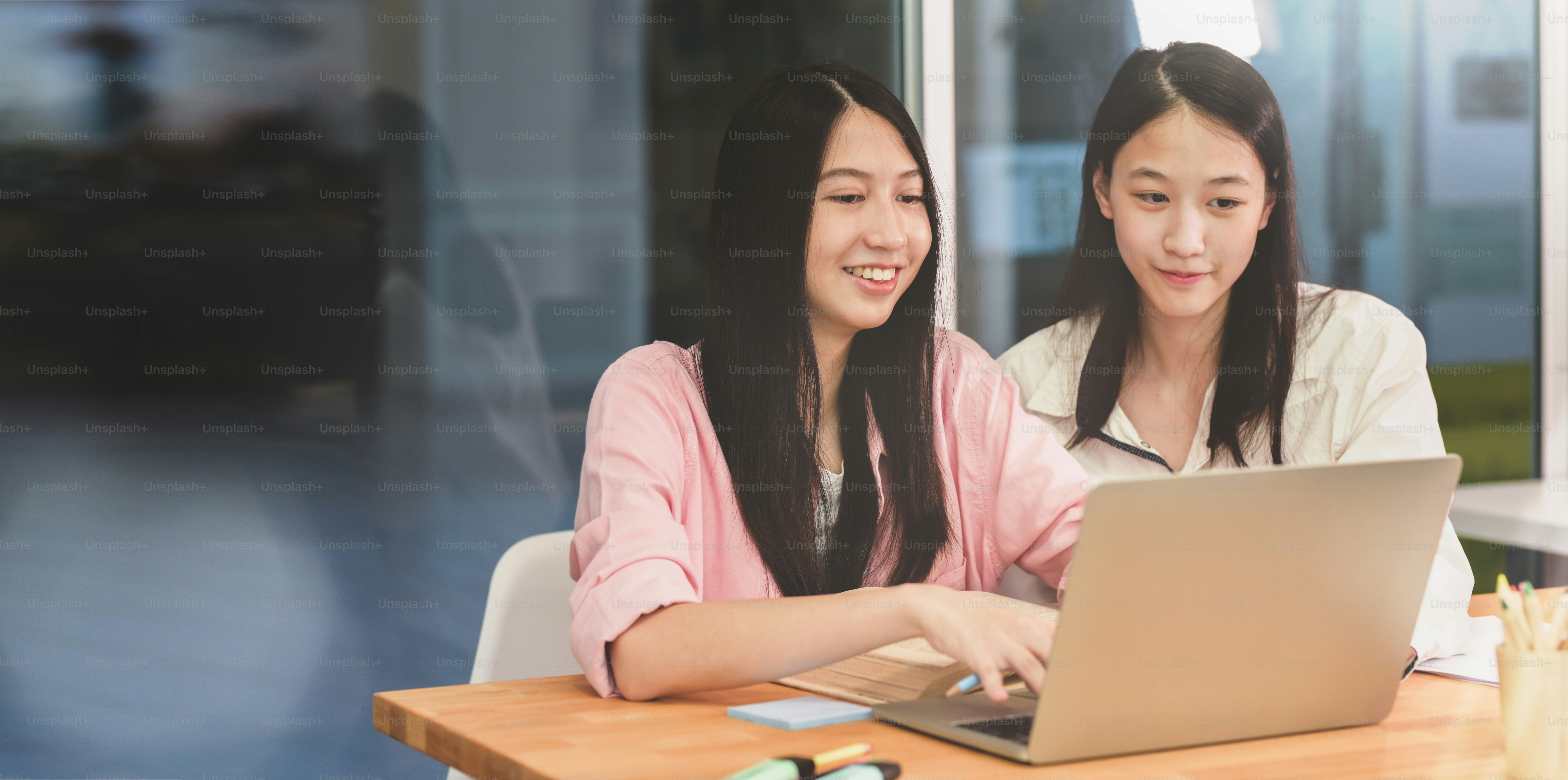 Group of cheerful young college students studying in the school library ...