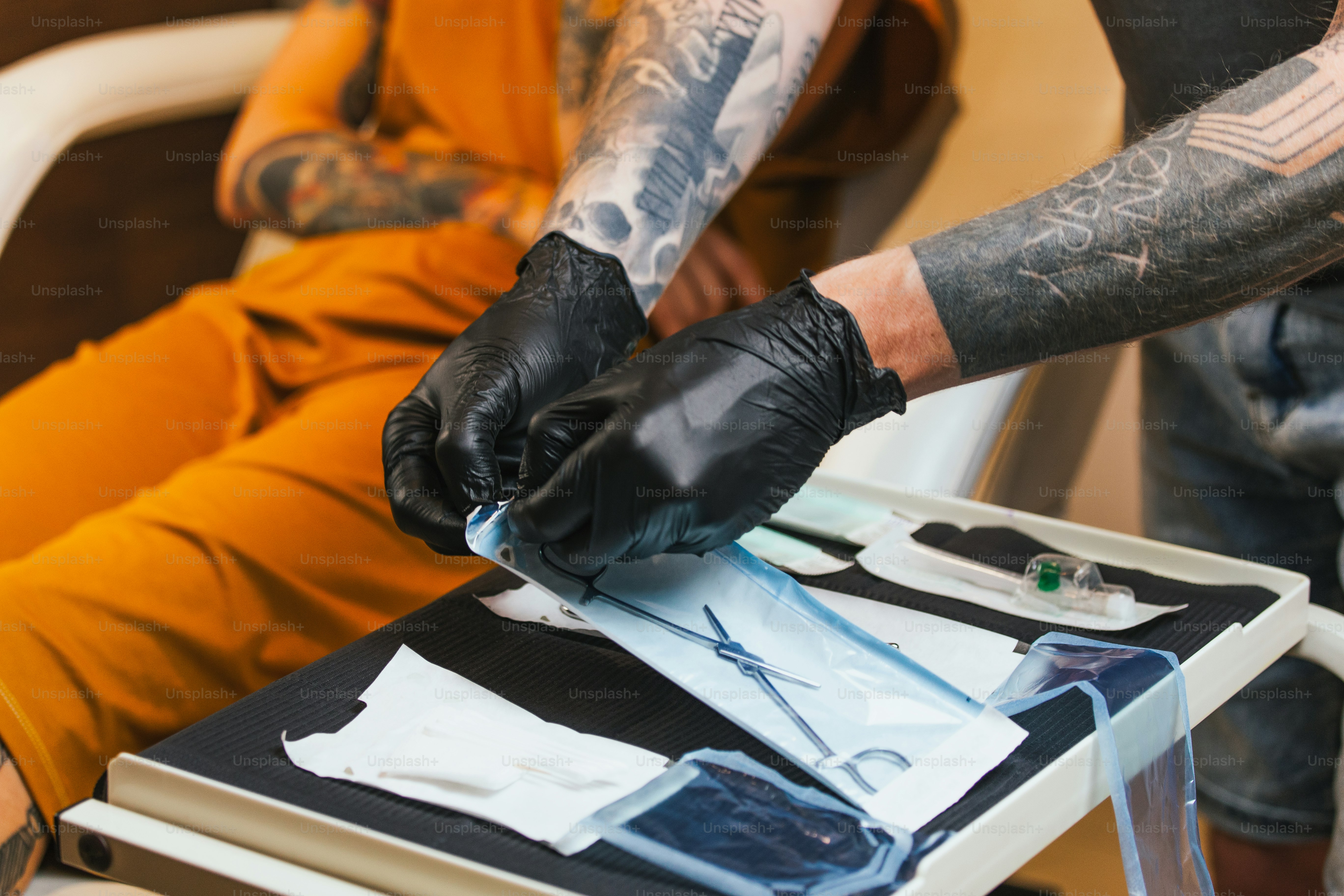 Close up of man opening steril equipment for piercing. Piercings ...