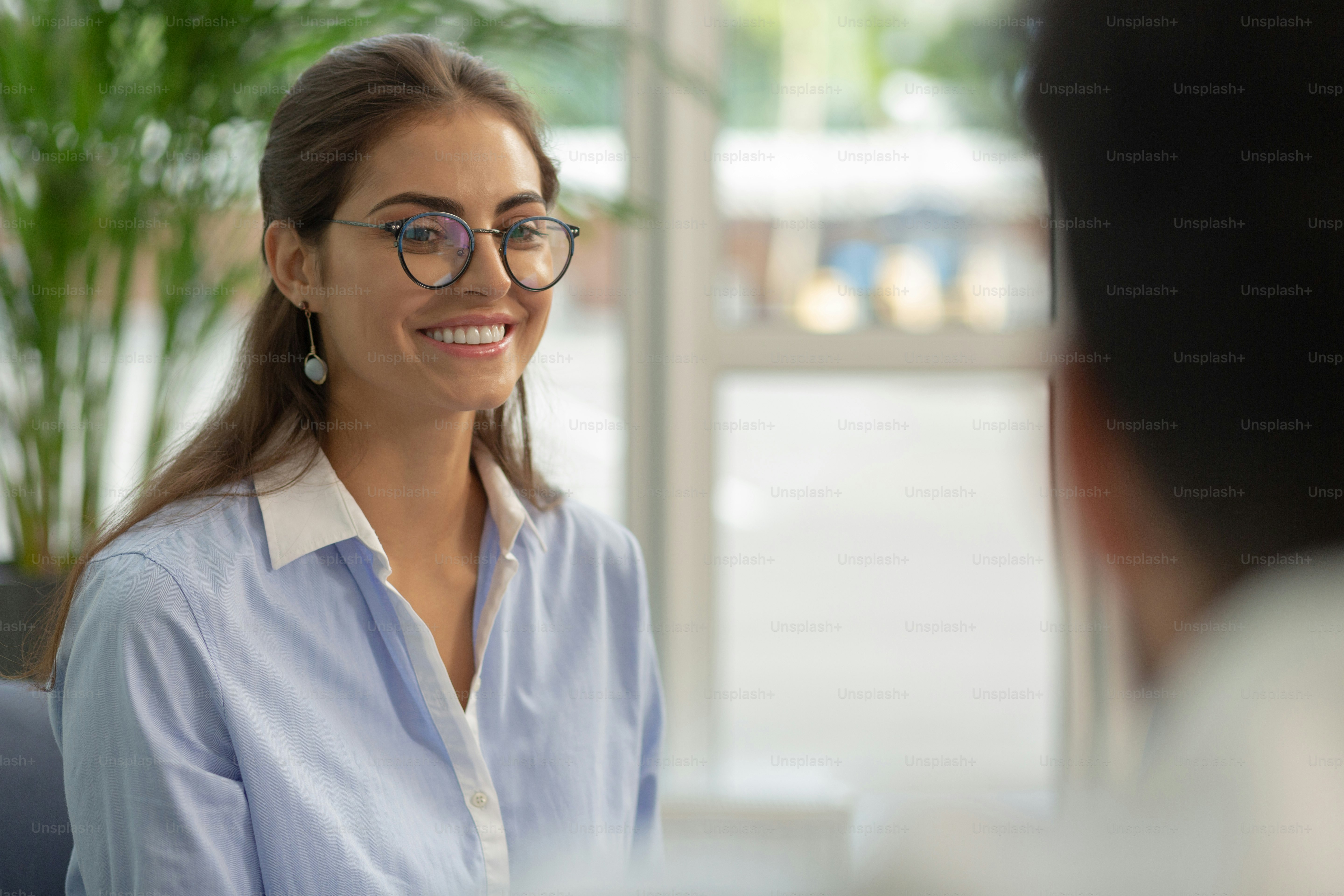 Successful startup. Cute office worker keeping smile on her face while ...
