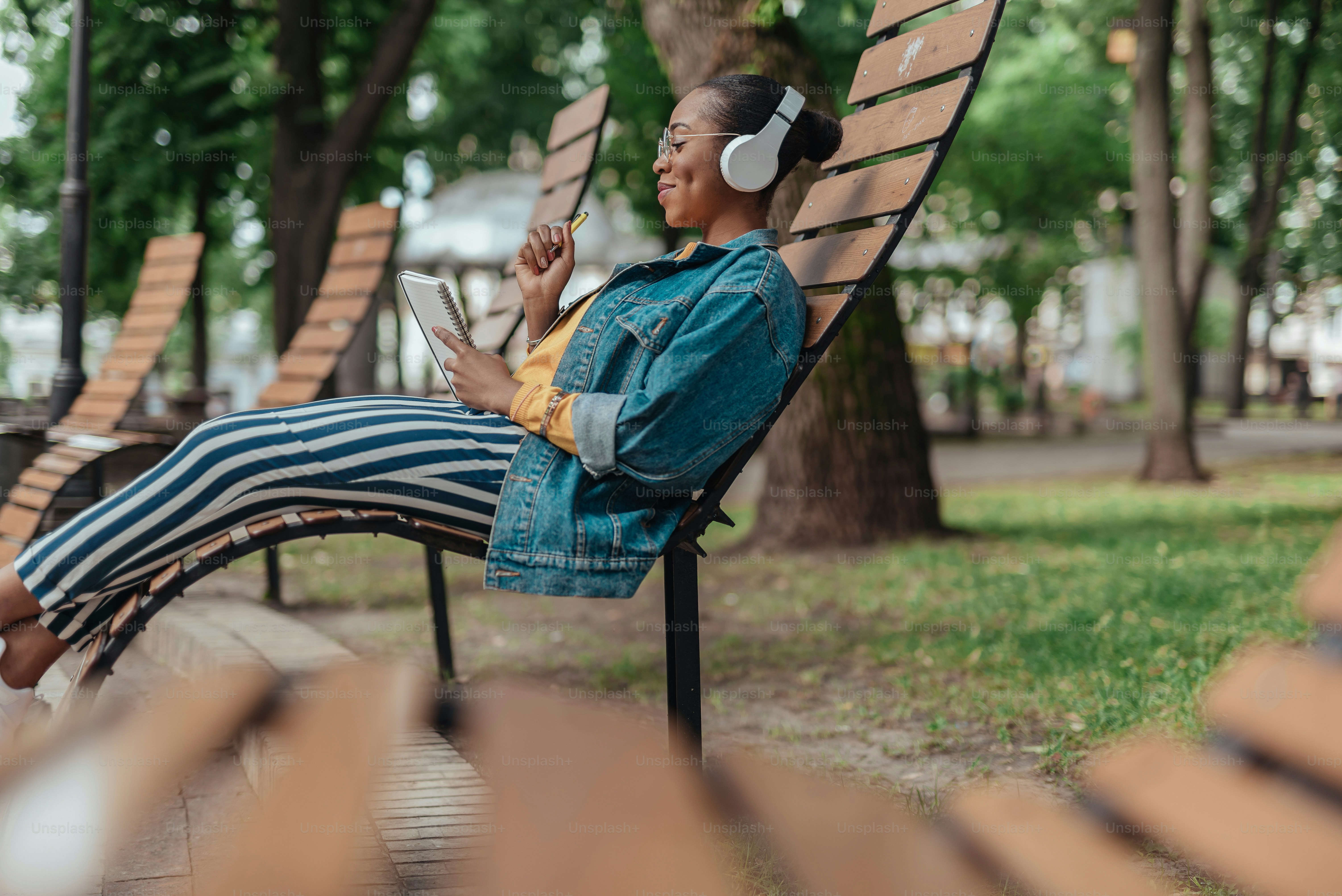 Cheerful and young african american woman in headset spending summer ...