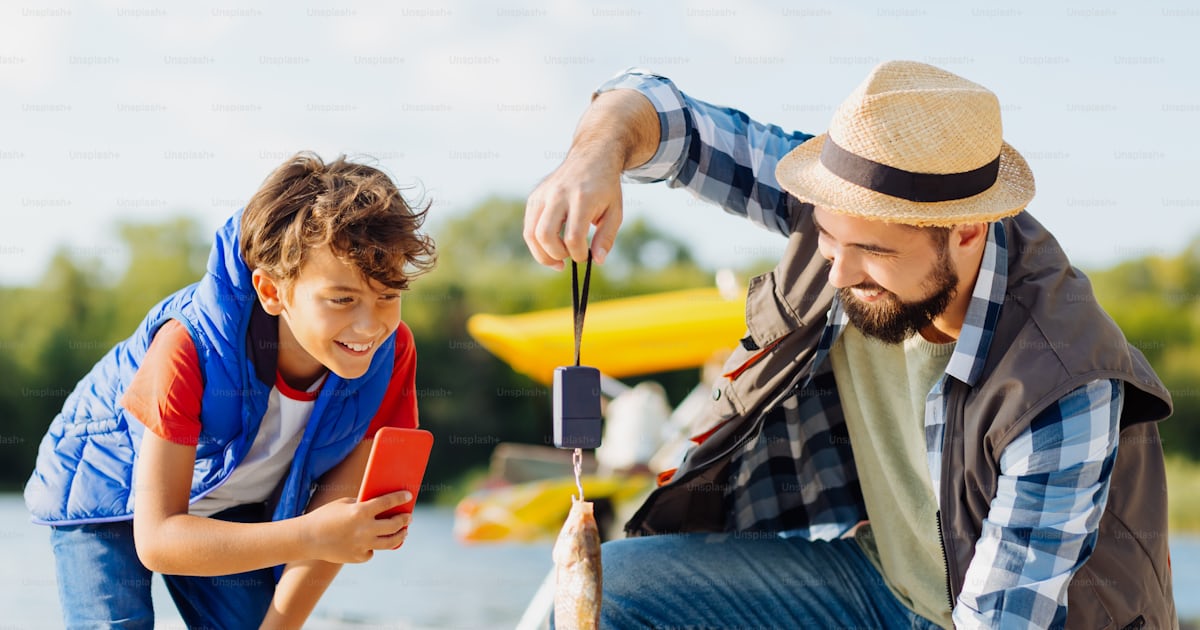 Papa A Pêché Du Poisson Un Beau Fils Excité Fait Une Photo Après Que Son Père Ait Attrapé De