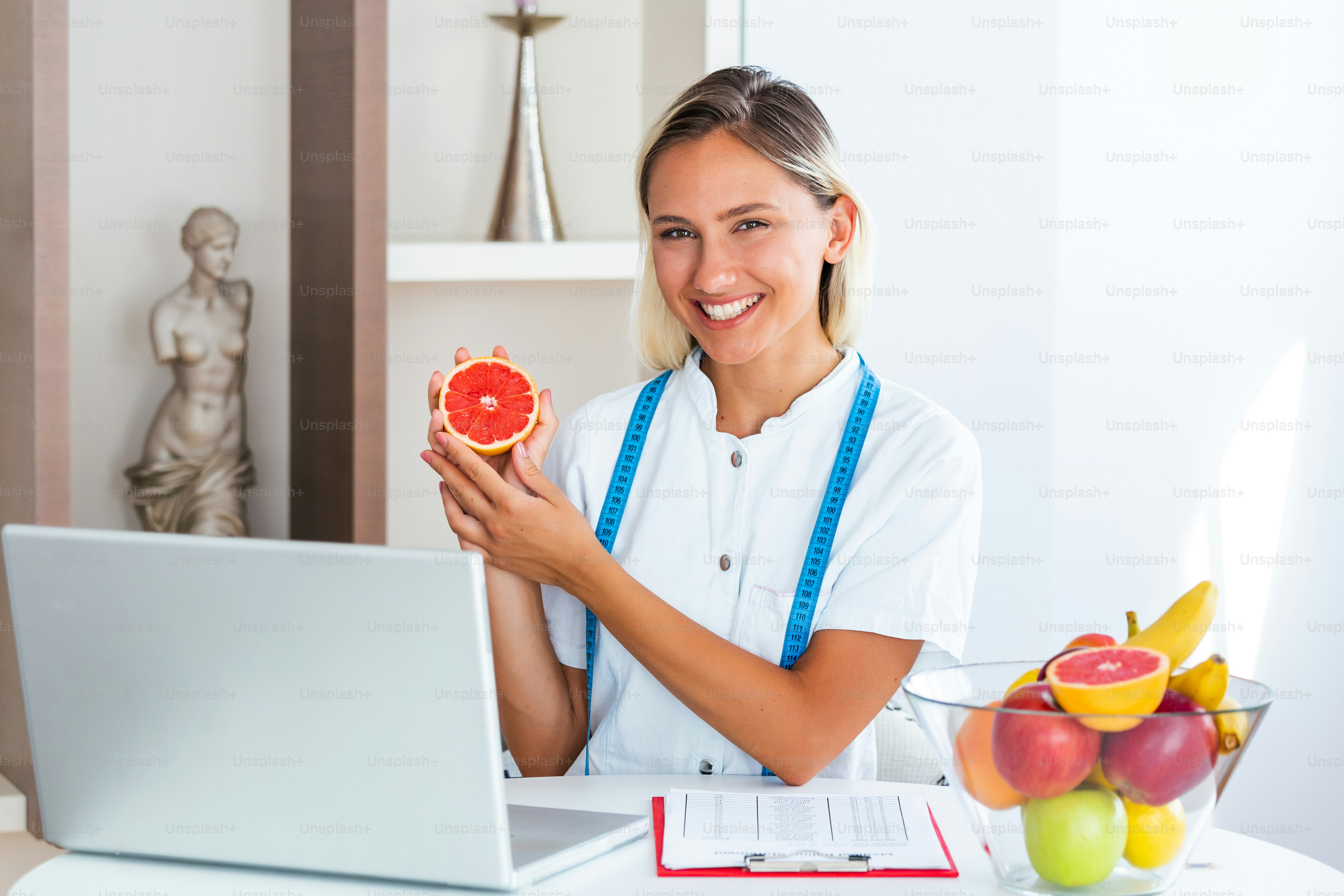 Portrait of young smiling female nutritionist in the consultation room ...