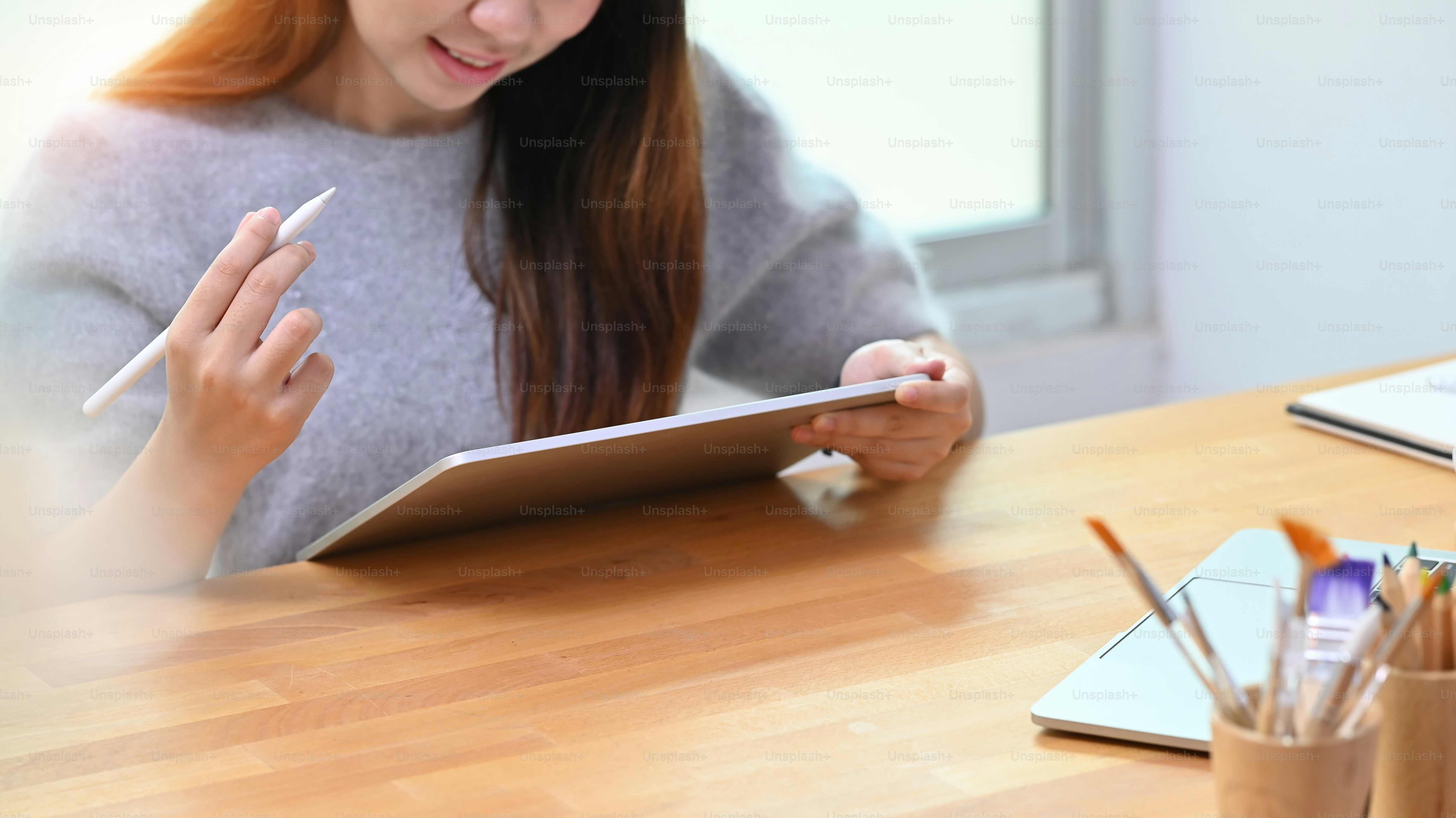 Nahaufnahme einer jungen Frau, die mit digitalem Tablet und Stift ...
