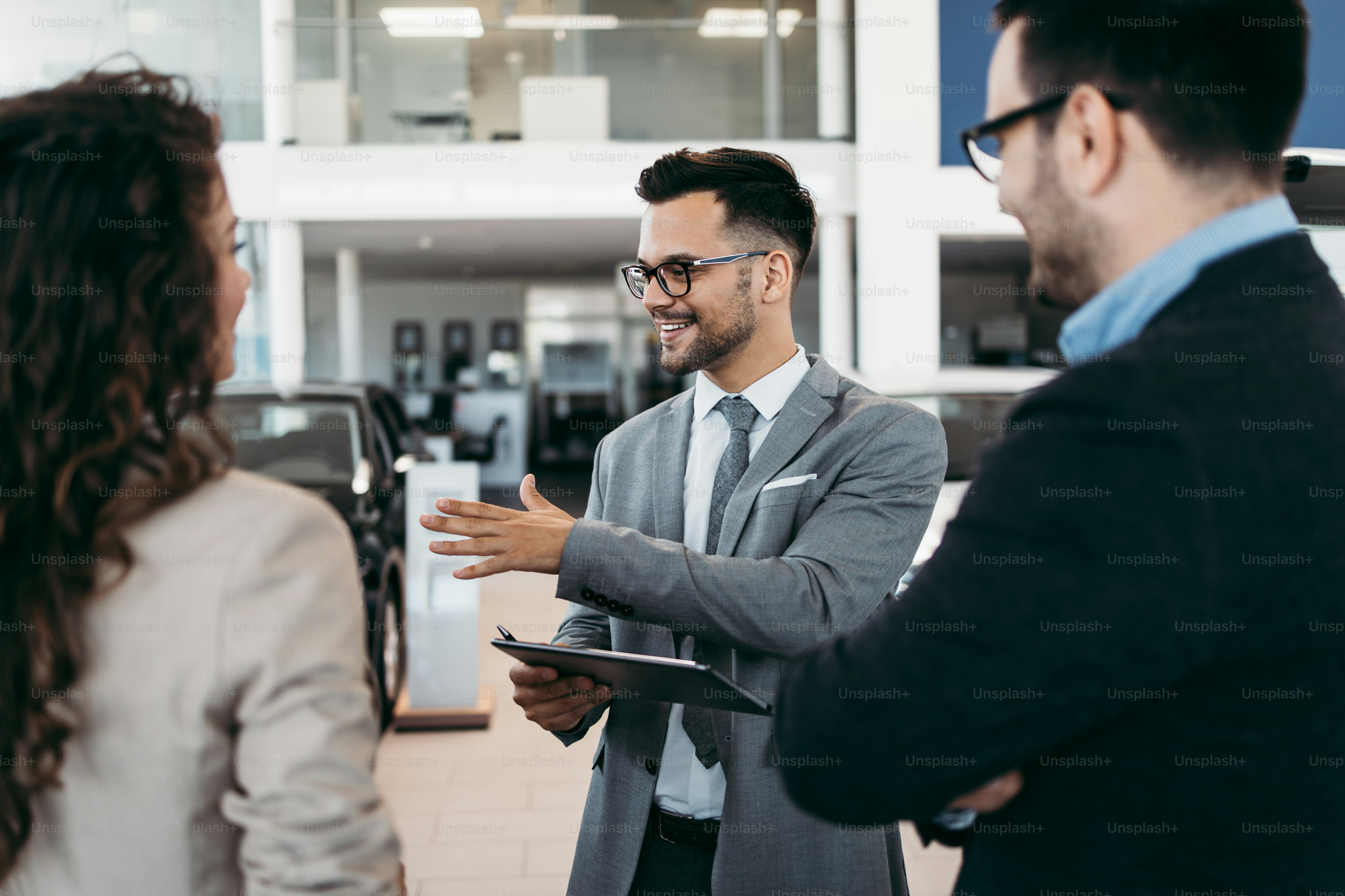 Good looking, cheerful and friendly salesman holding keys and posing in ...
