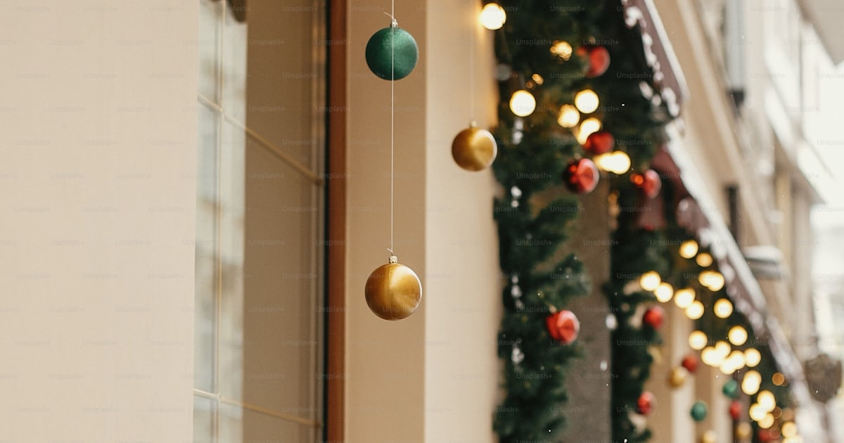 クリスマス通りの装飾。スタイリッシュなクリスマスのモミの枝で、金色のライトと、街の通りのホリデー マーケットの店の窓にカラフルなお祝いつまら