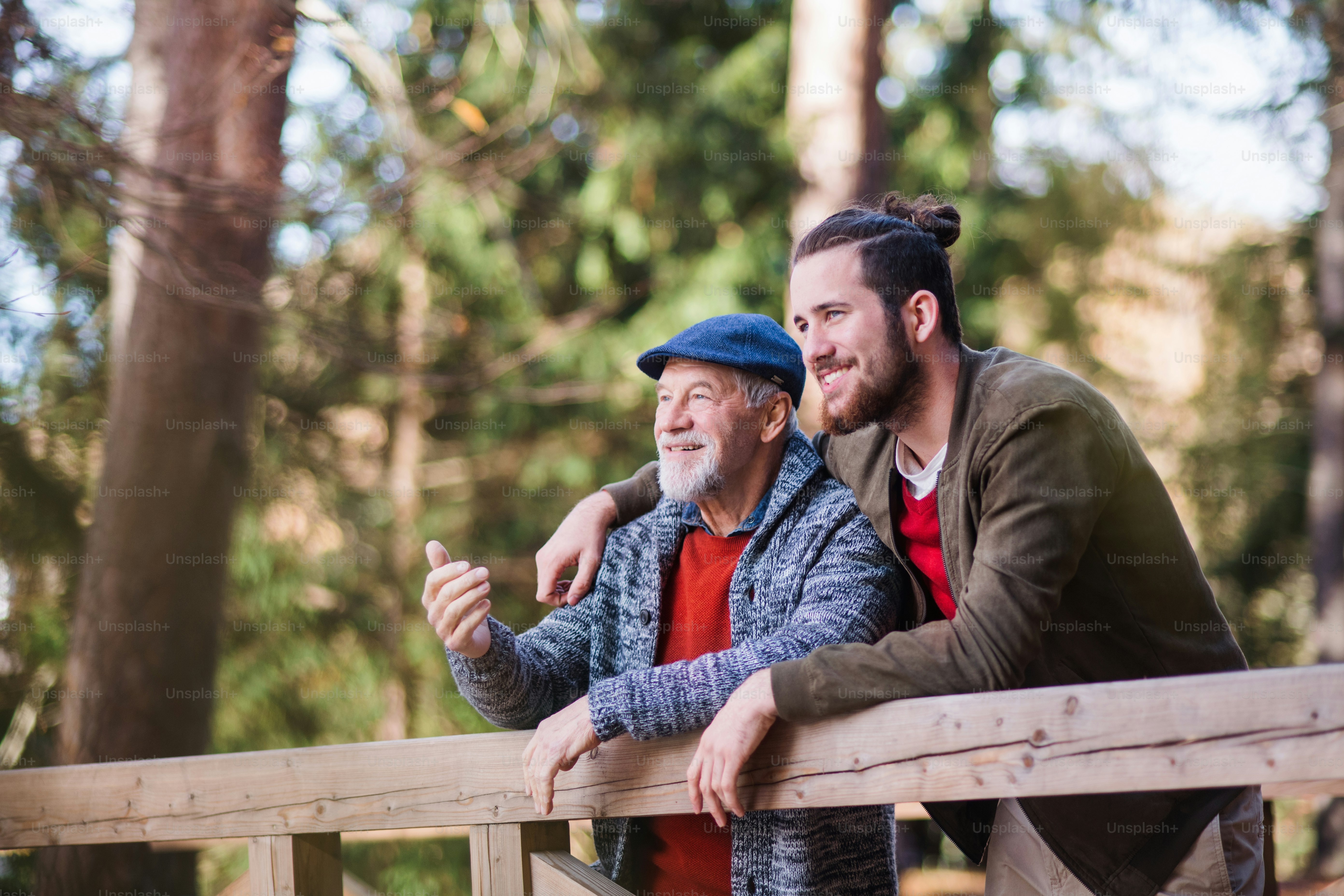 A senior father and his son on walk in nature, standing and talking ...