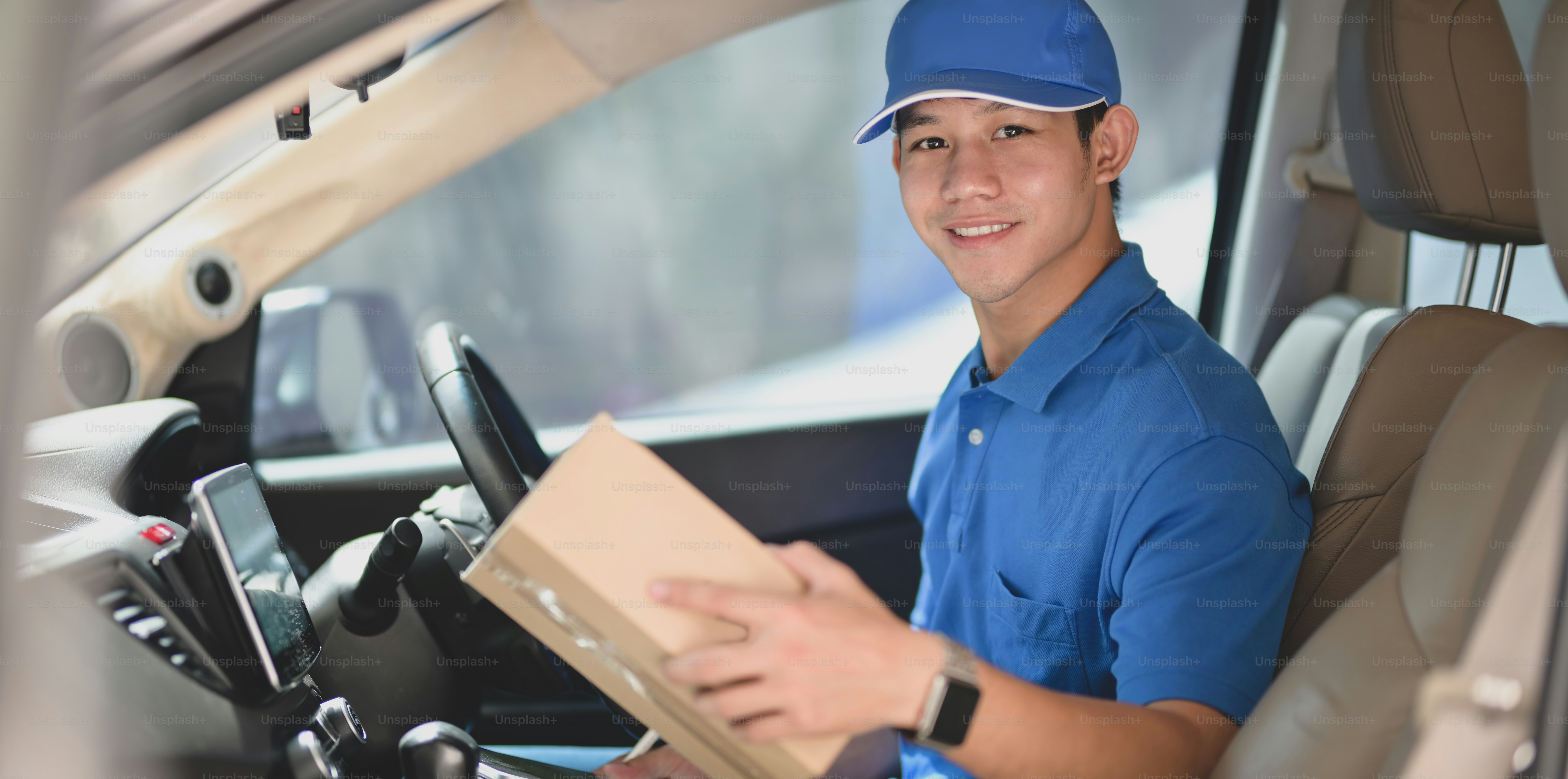 Foto zum Thema Junger Zusteller, der die Produkte mit dem Tablet an den ...