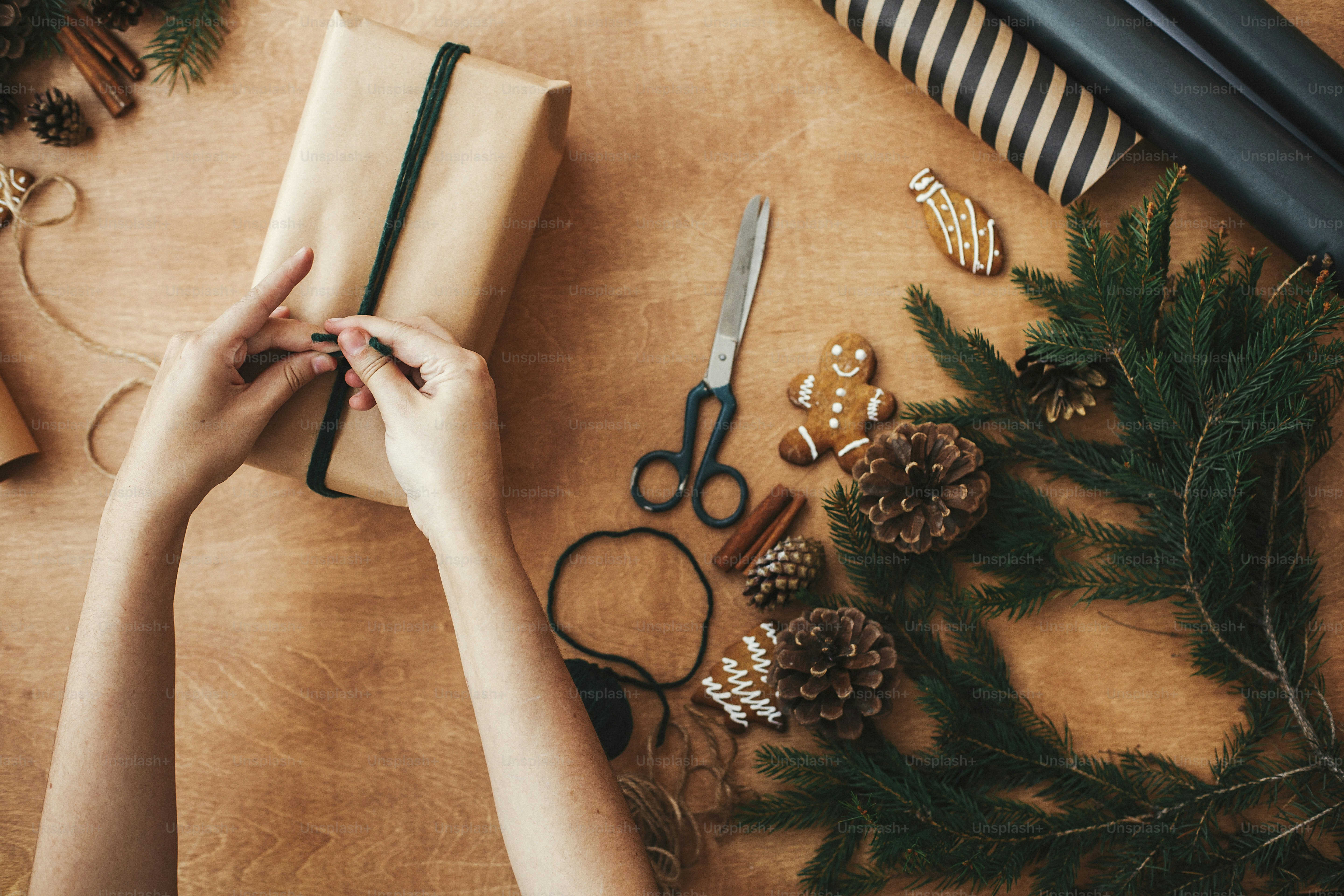 Wrapping stylish christmas gifts. Hands wrapping rustic christmas gift ...