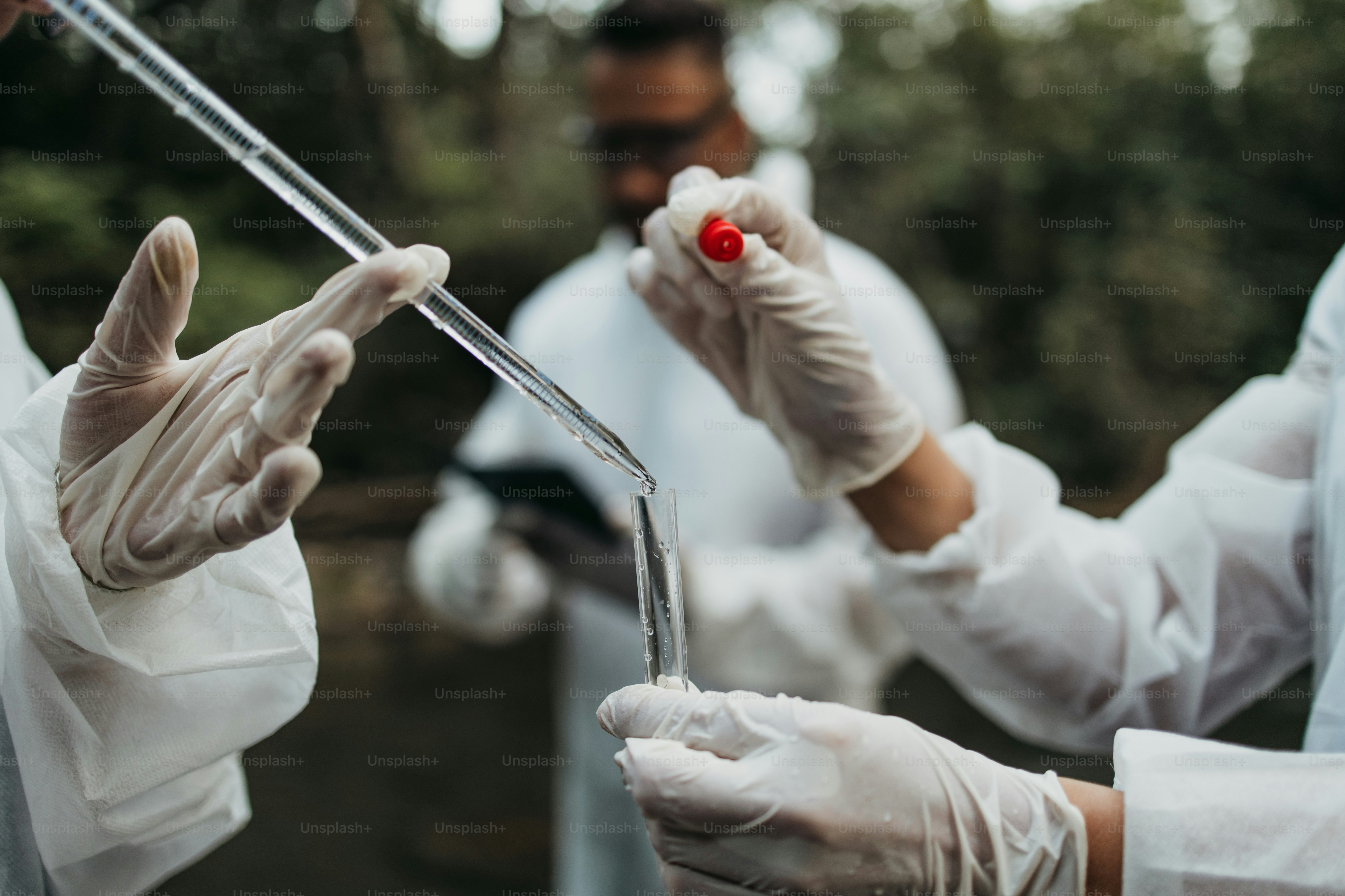 Scientists biologists and researchers in protective suits taking water ...