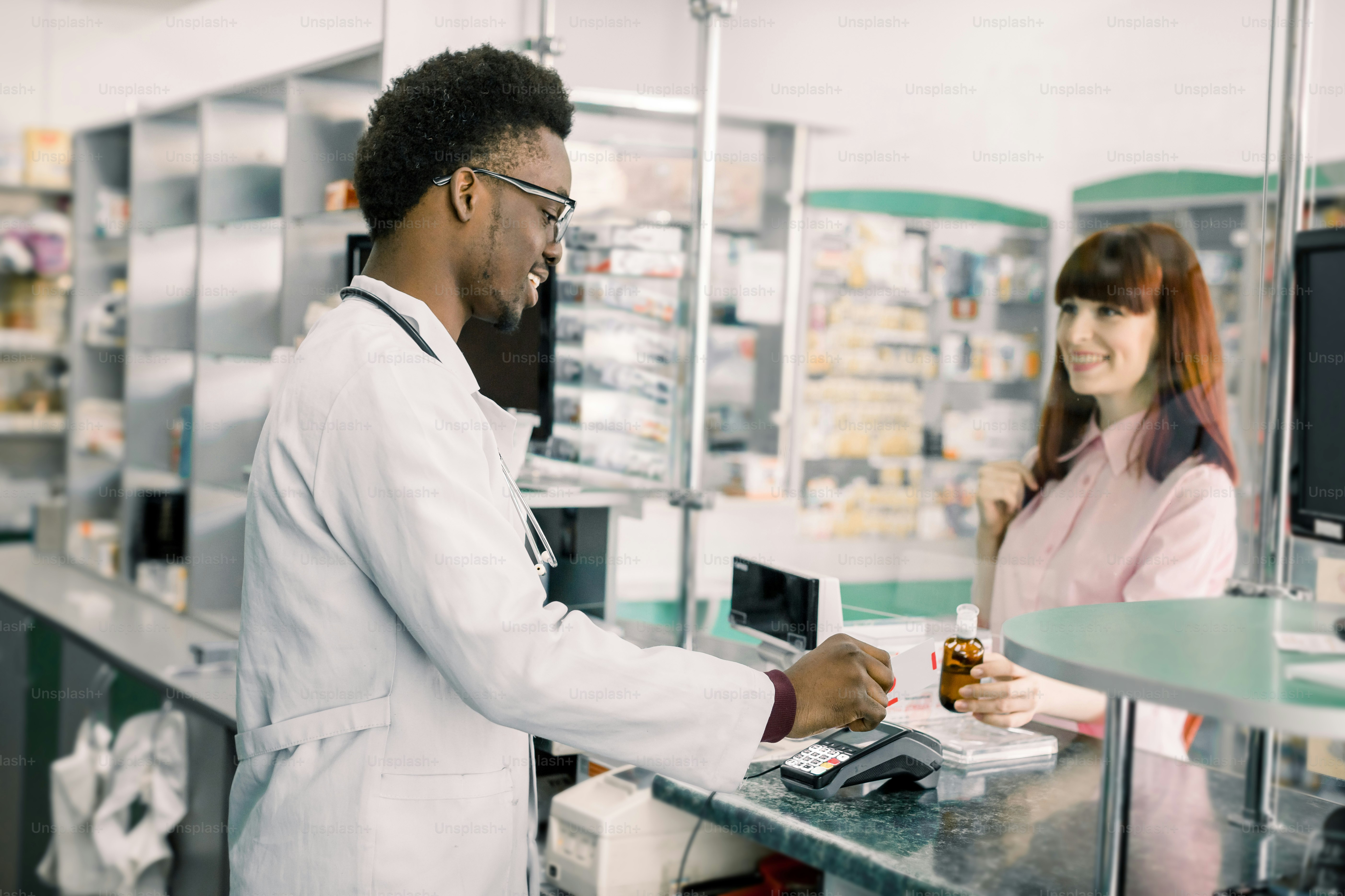 Pretty young Caucasian woman paying for mediciens with credit card in ...