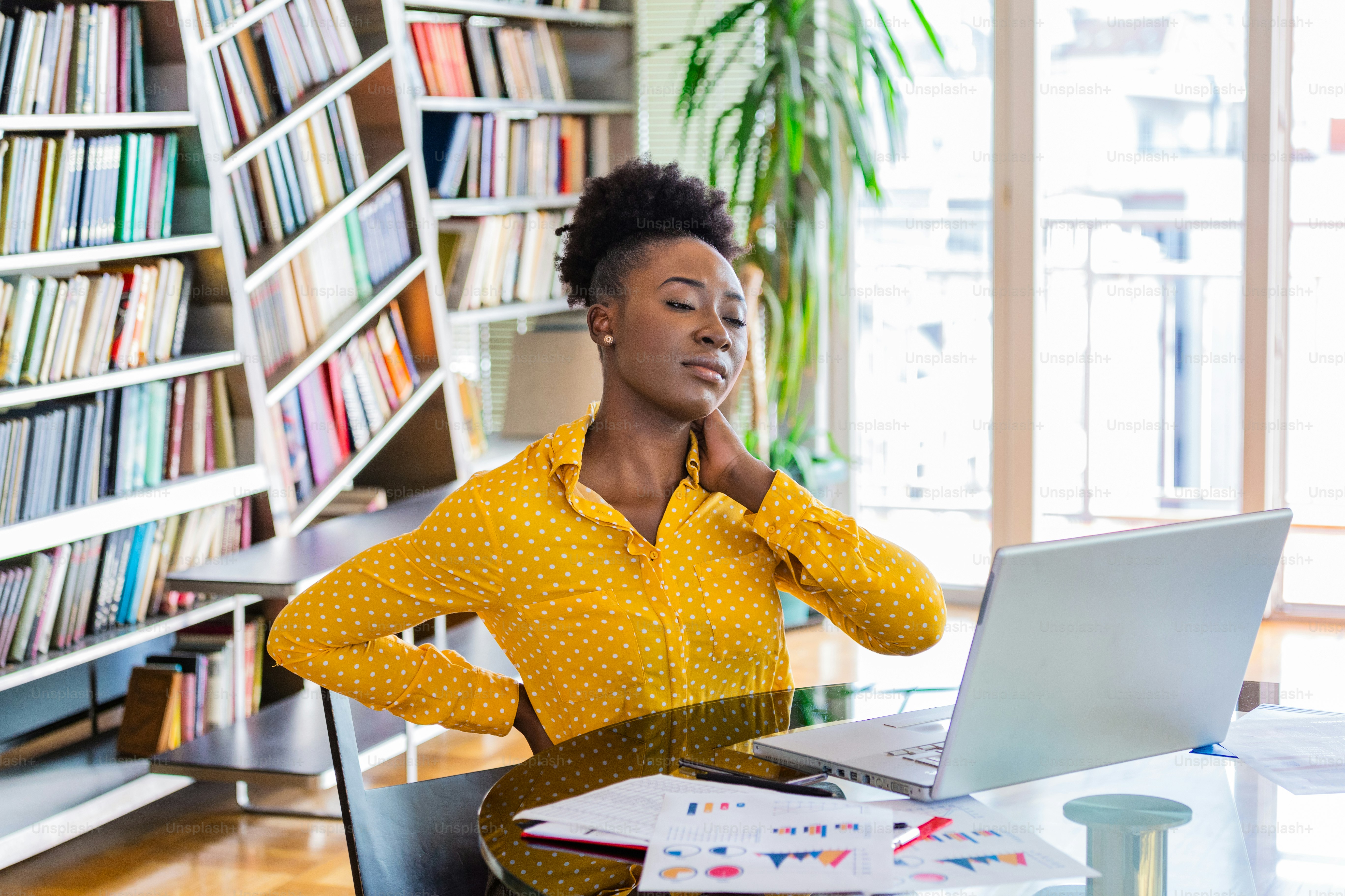 Portrait of young black stressed woman sitting at home office desk in ...