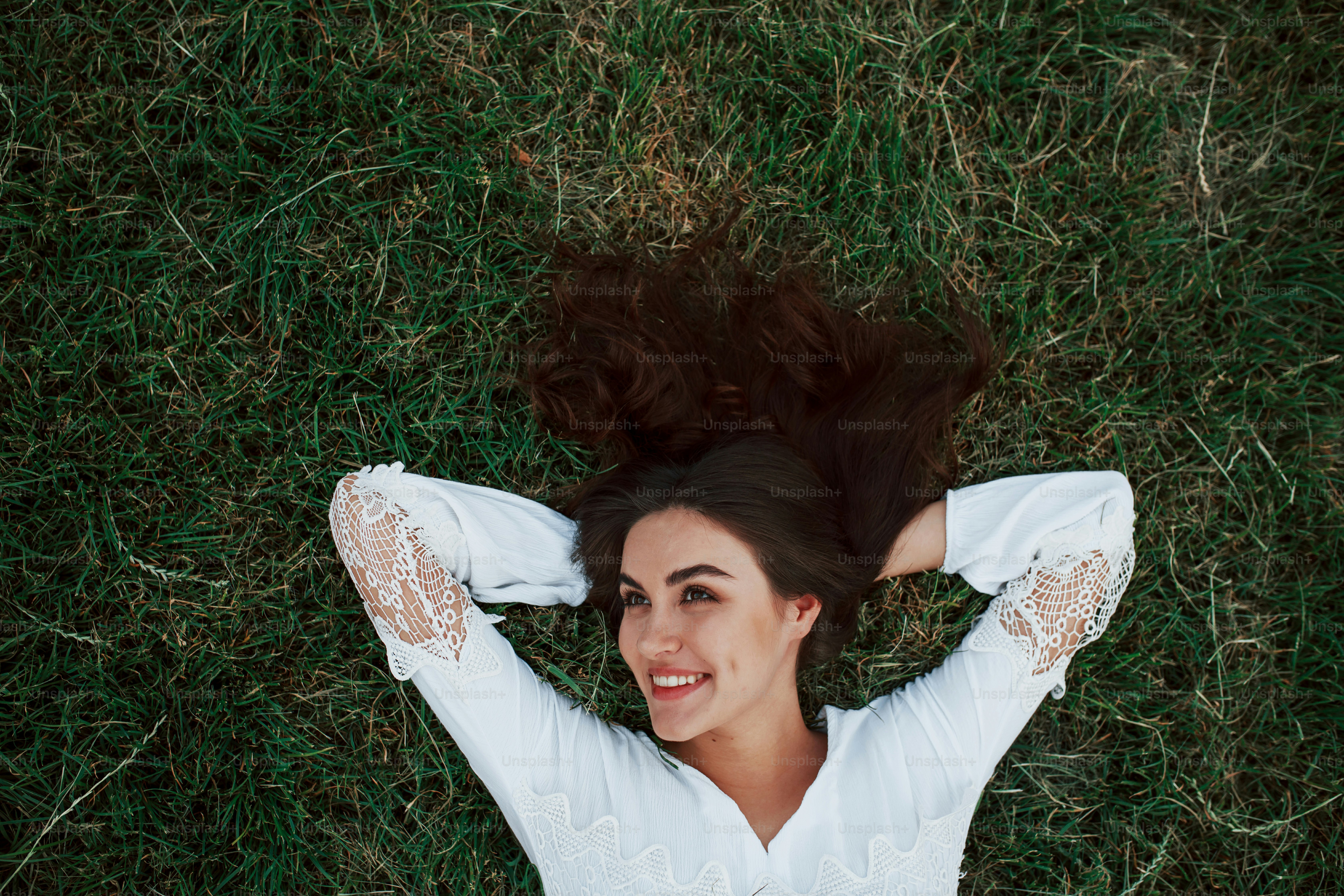Feels freedom. Girl lying down on the green grass and have a rest ...