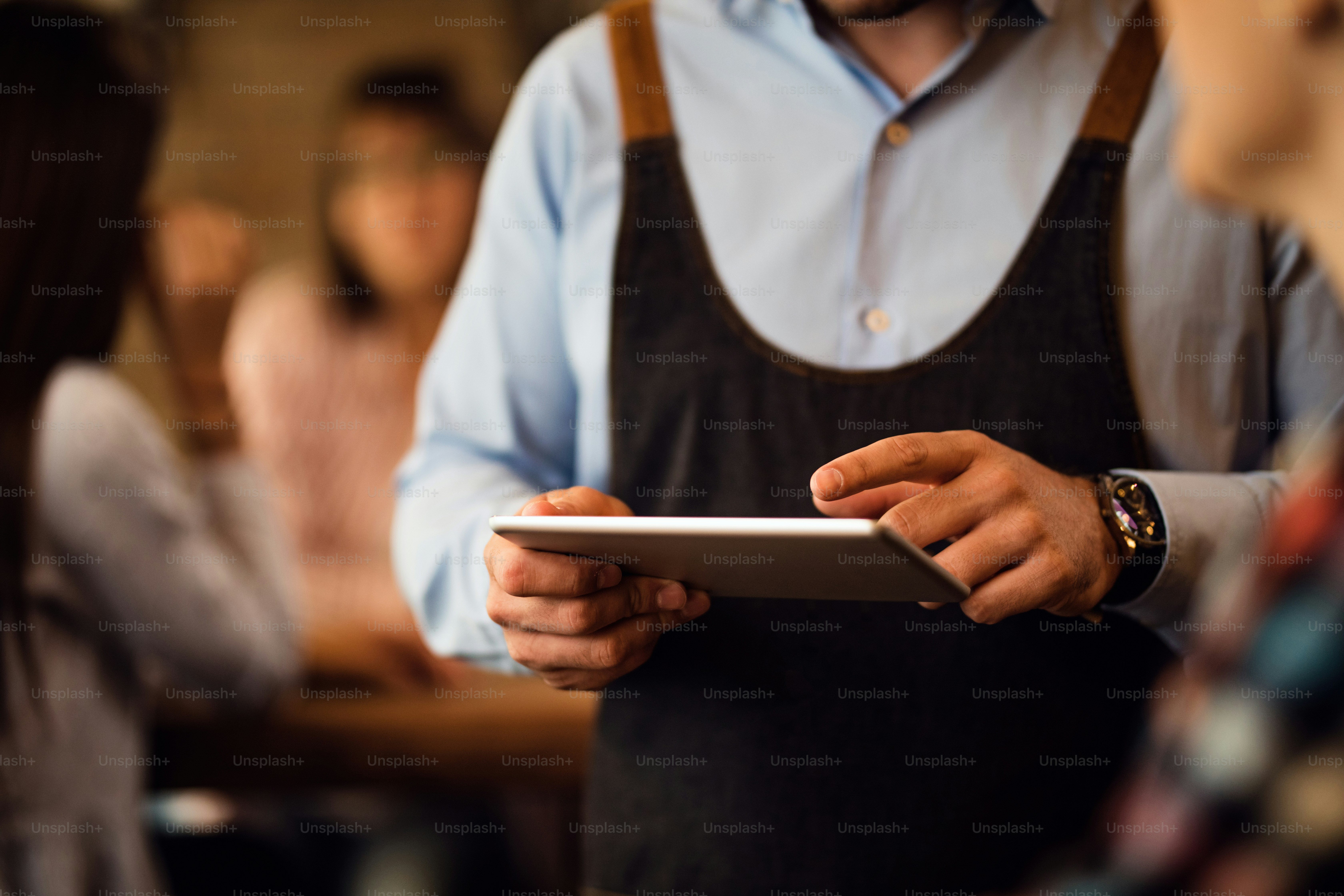 Close-up of unrecognizable waiter using touchpad in a bar. photo ...