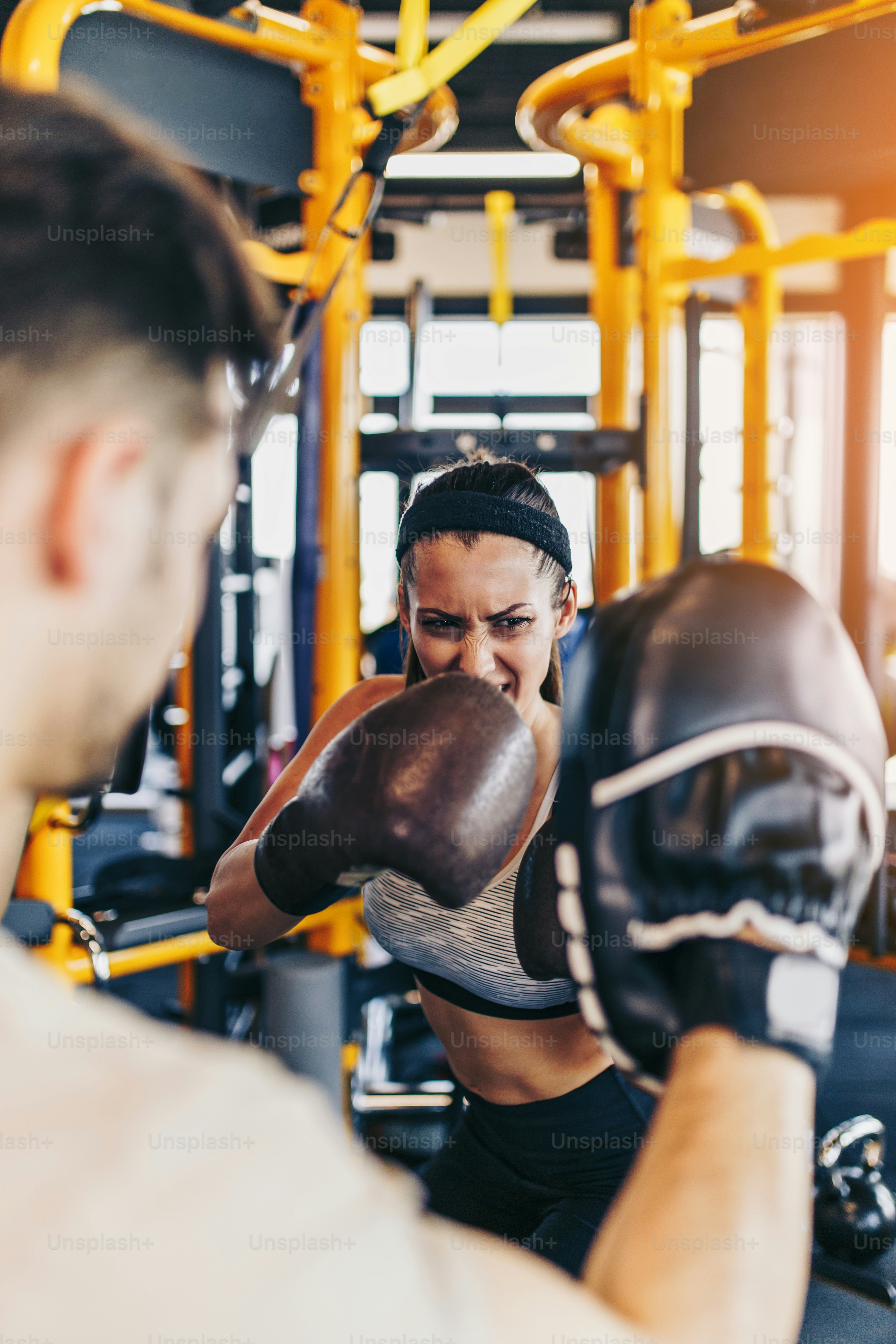 Young attractive woman with instructor on kickboxing training. She ...