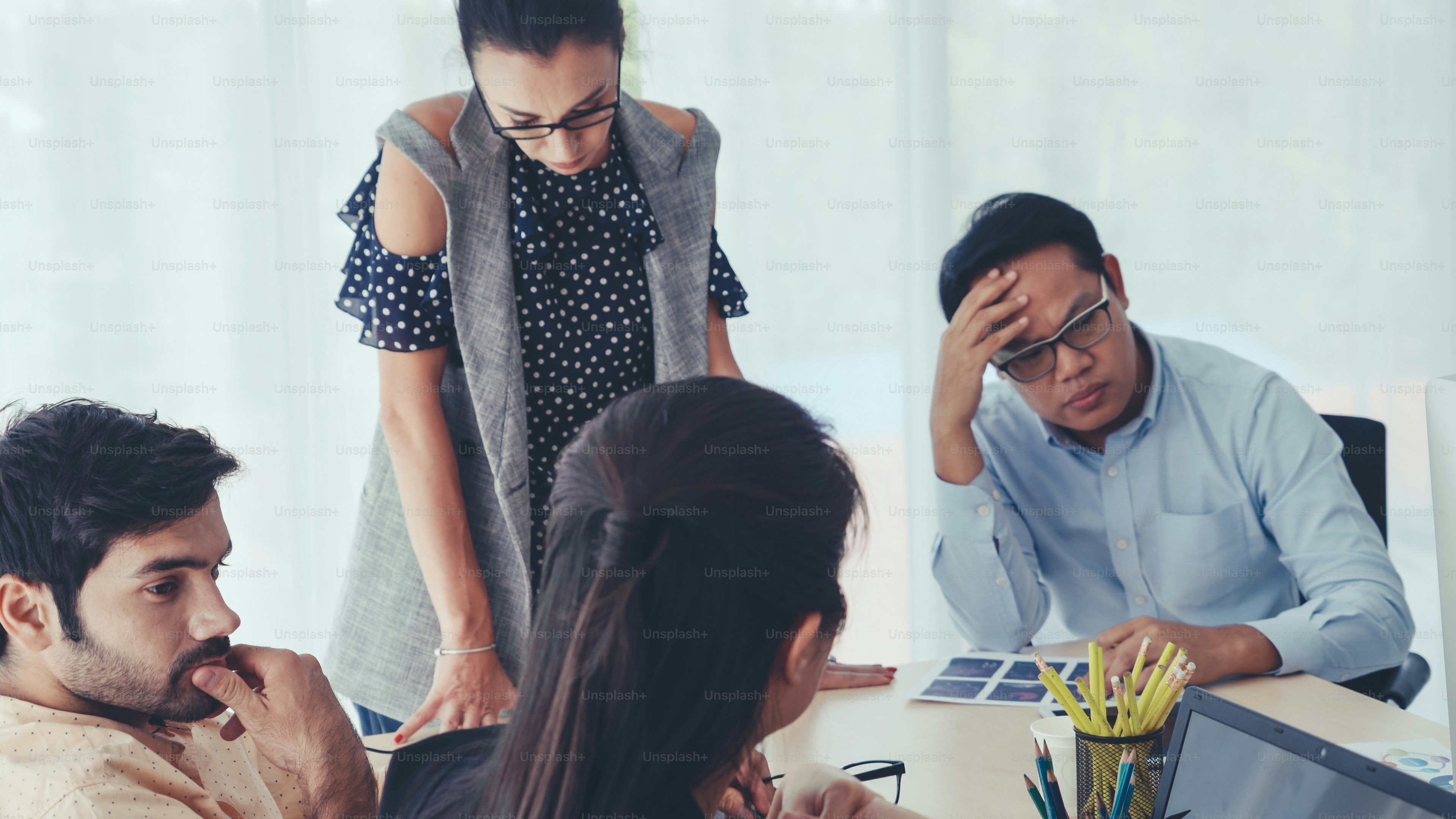 Unhappy business people in group meeting in office. The team is ...