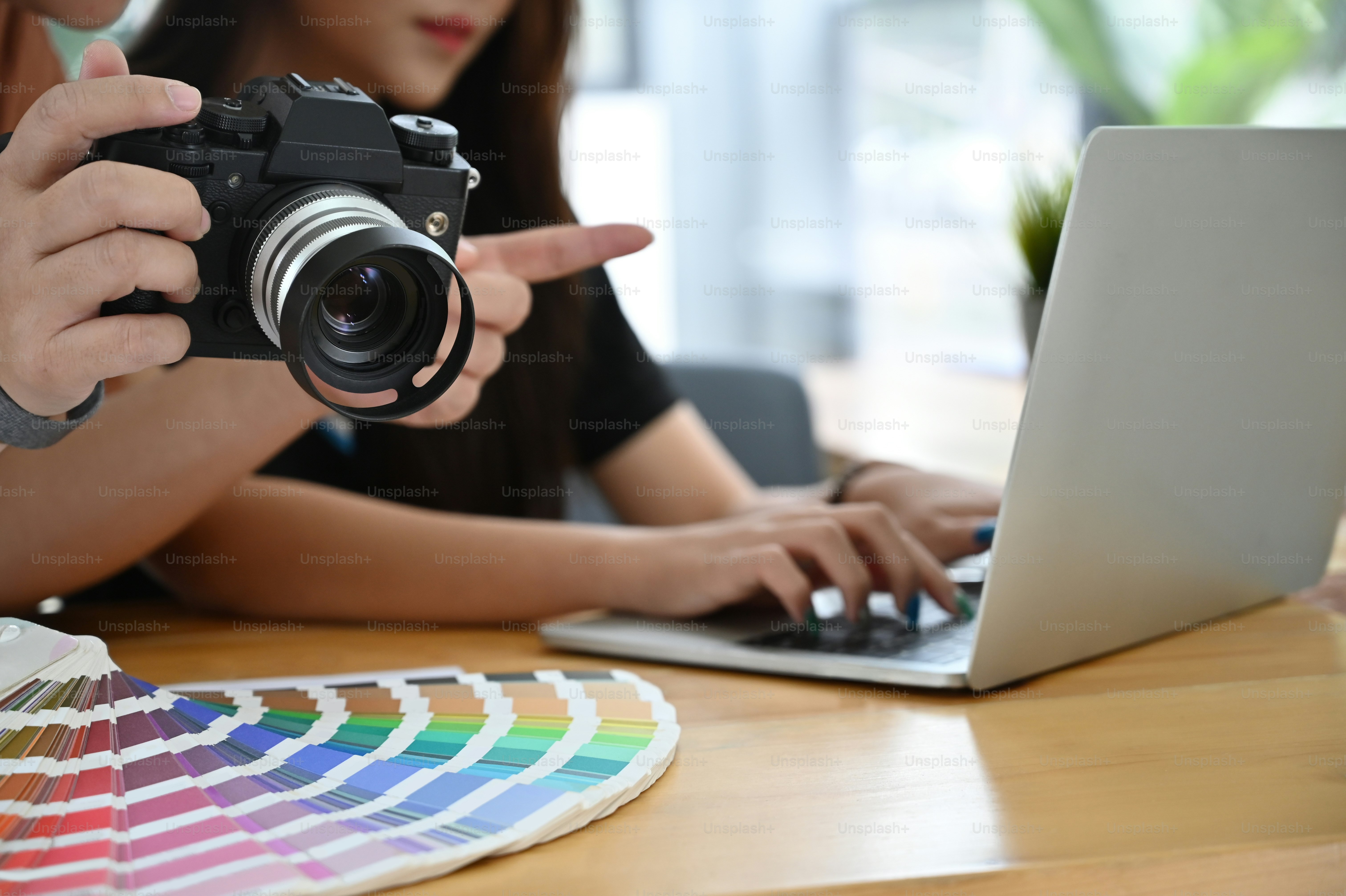 Photographer and partners working with laptop and colouring concept ...