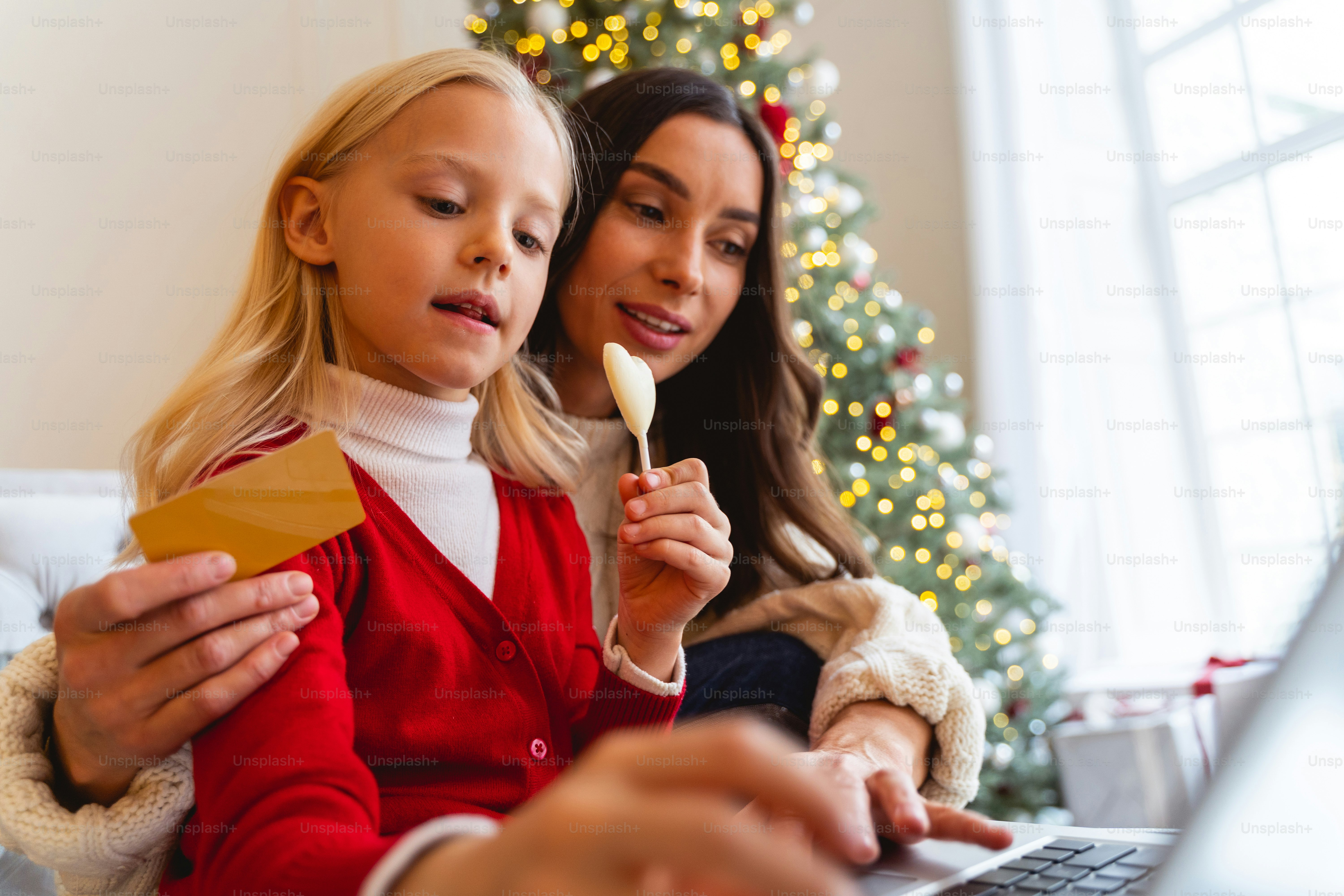 Pleased pretty woman and her girl buying Christmas gifts online photo ...