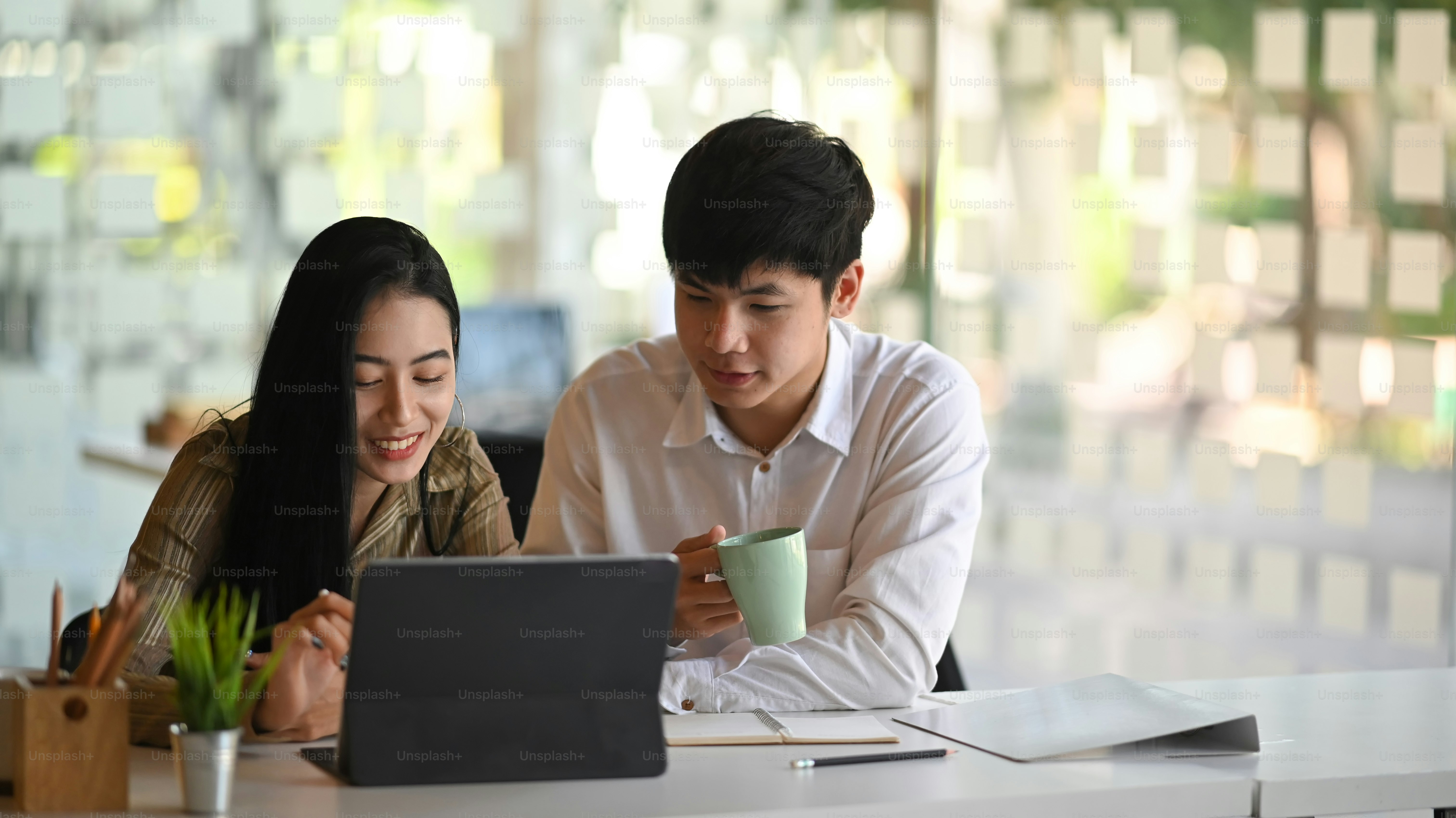 Two colleagues working with tablet in modern office. photo – Thailand ...