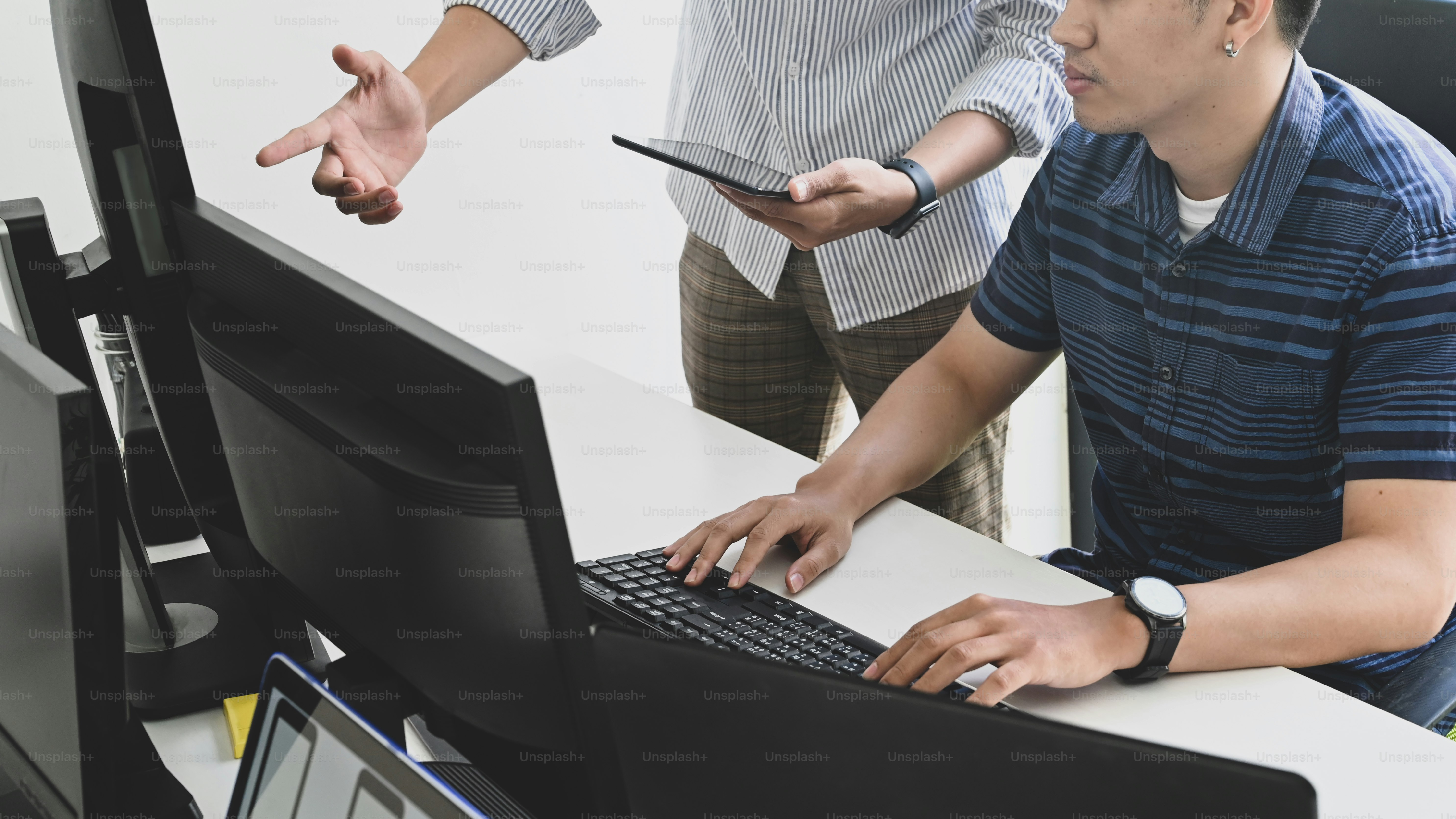 Young programmers working on computer and tablet in modern office ...